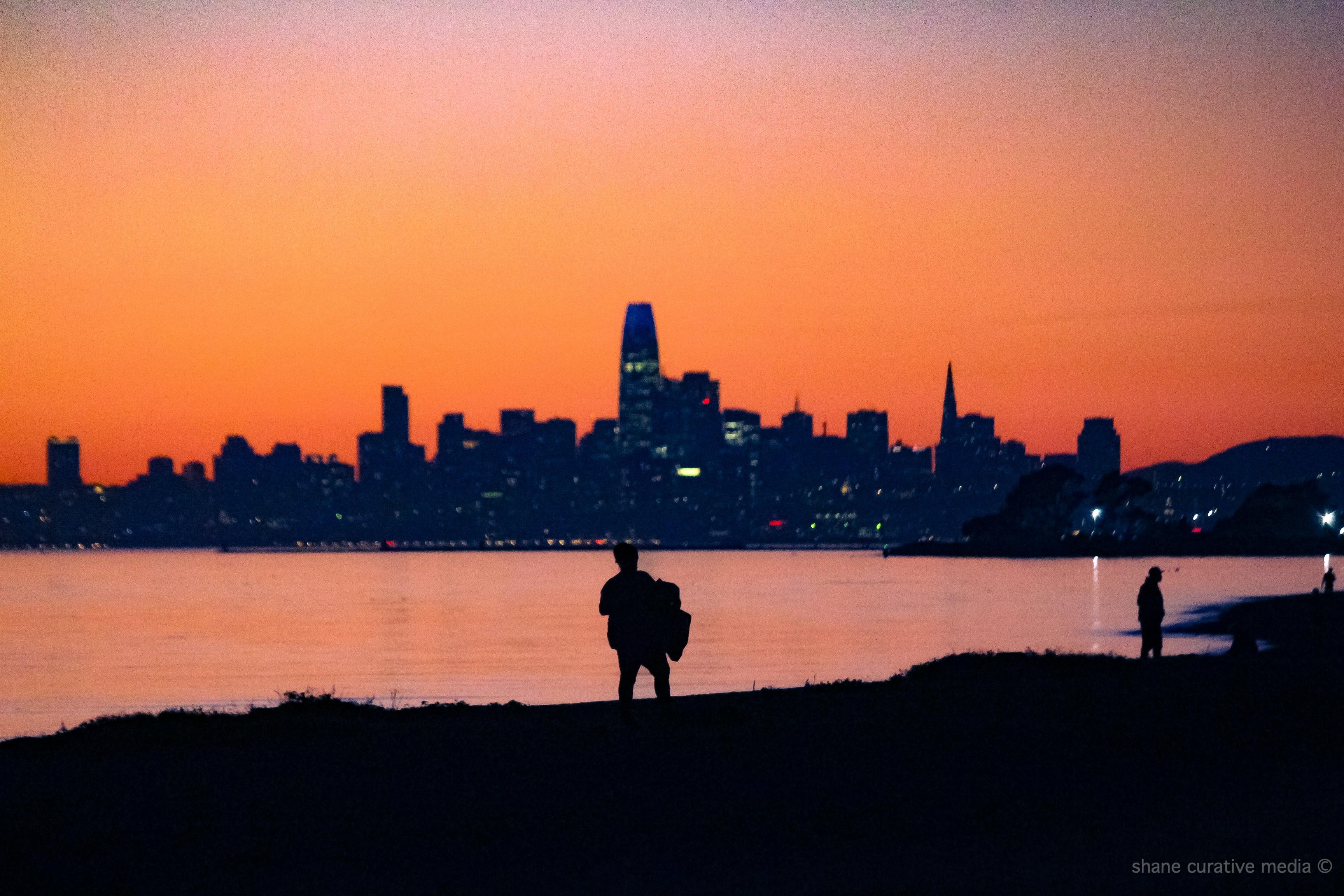 Dusk Silhouette Over the Harbor: A Lone Figure Against the City Horizon