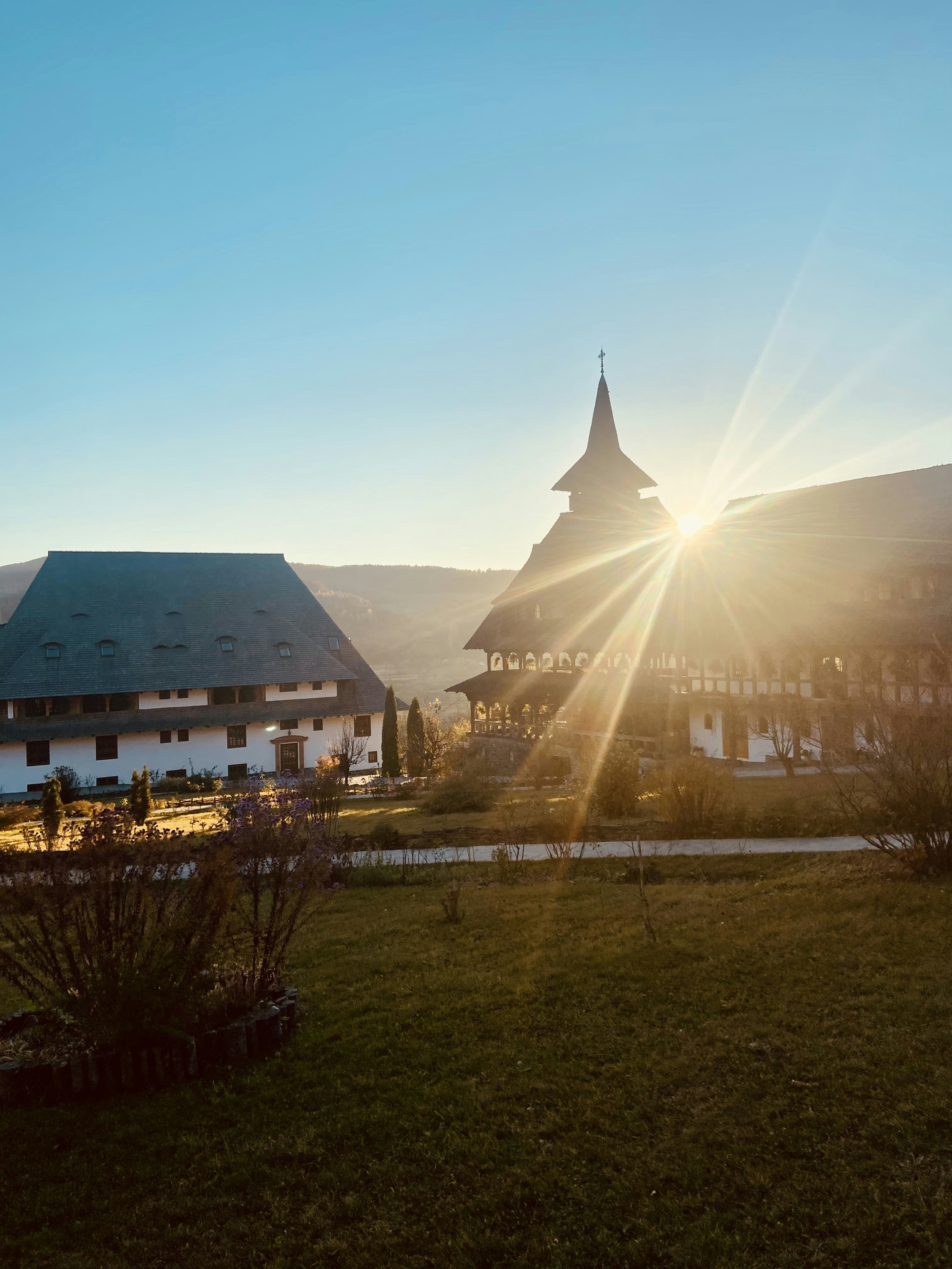 Dawn Sunburst Over Alpine Timbered Chapel