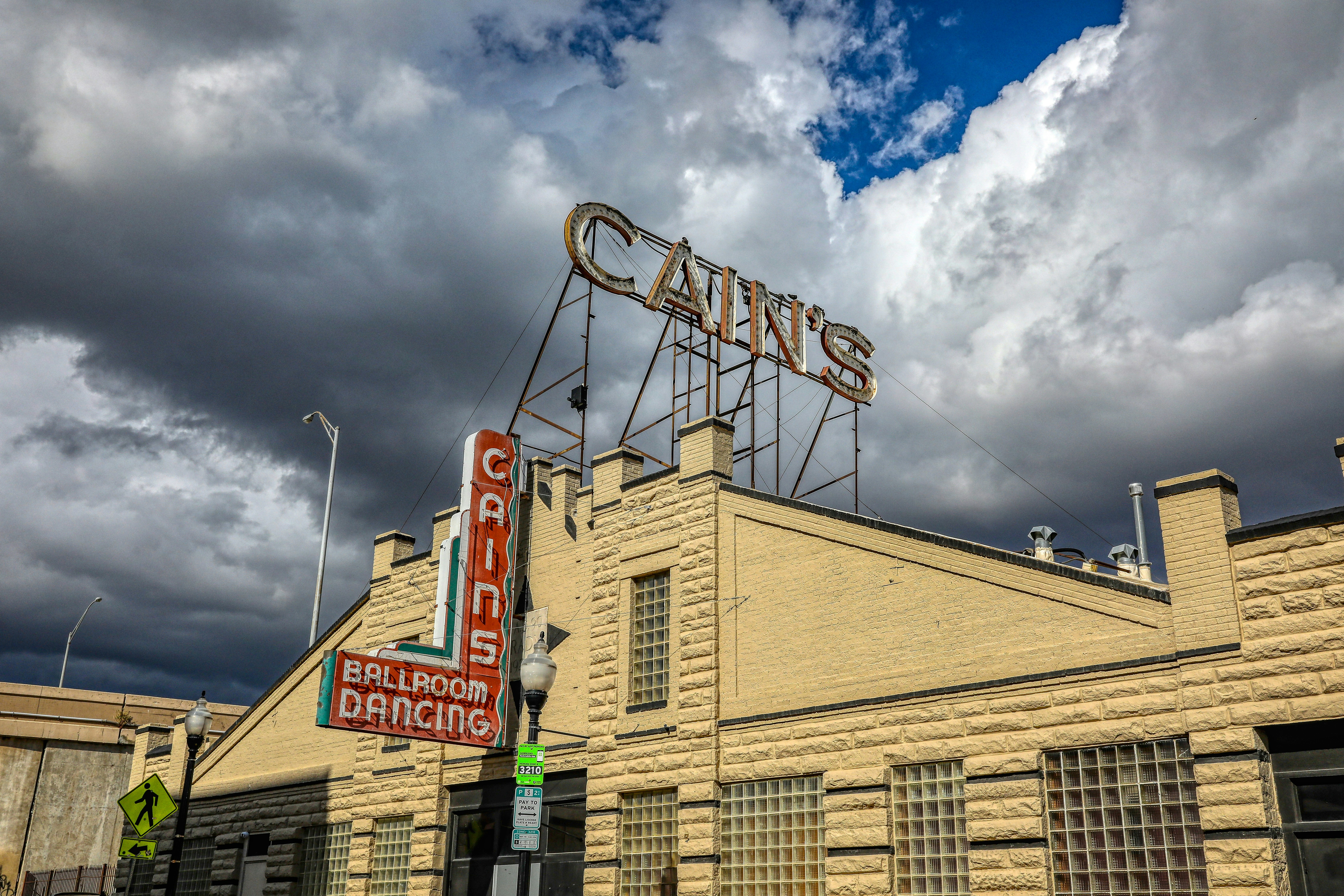 CAIN'S Neon Crown Above a Weathered Brick Ballroom