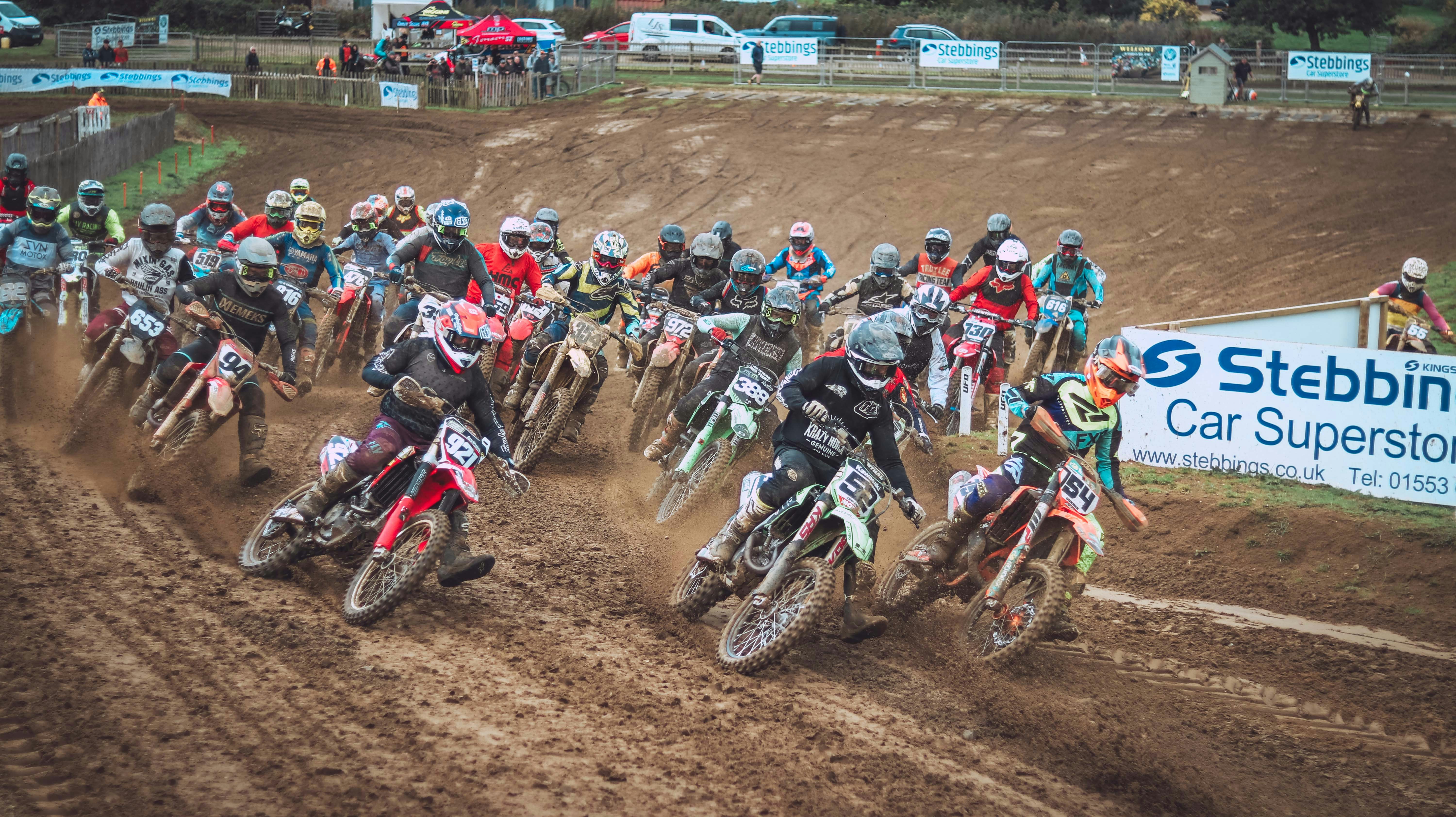 A group of people riding dirt bikes on a dirt track photo – Free ...