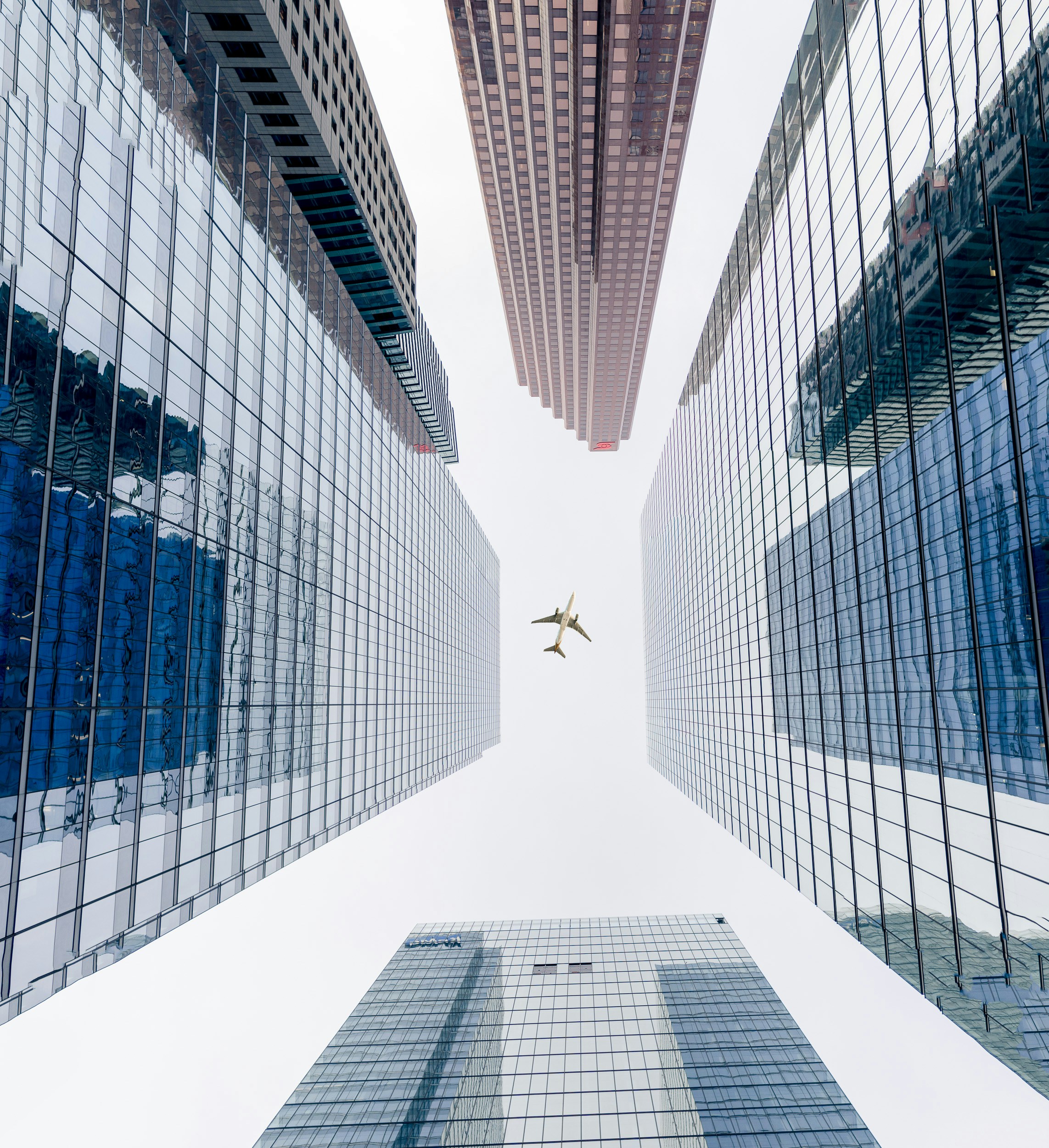 An airplane flying through the air between two tall buildings photo ...