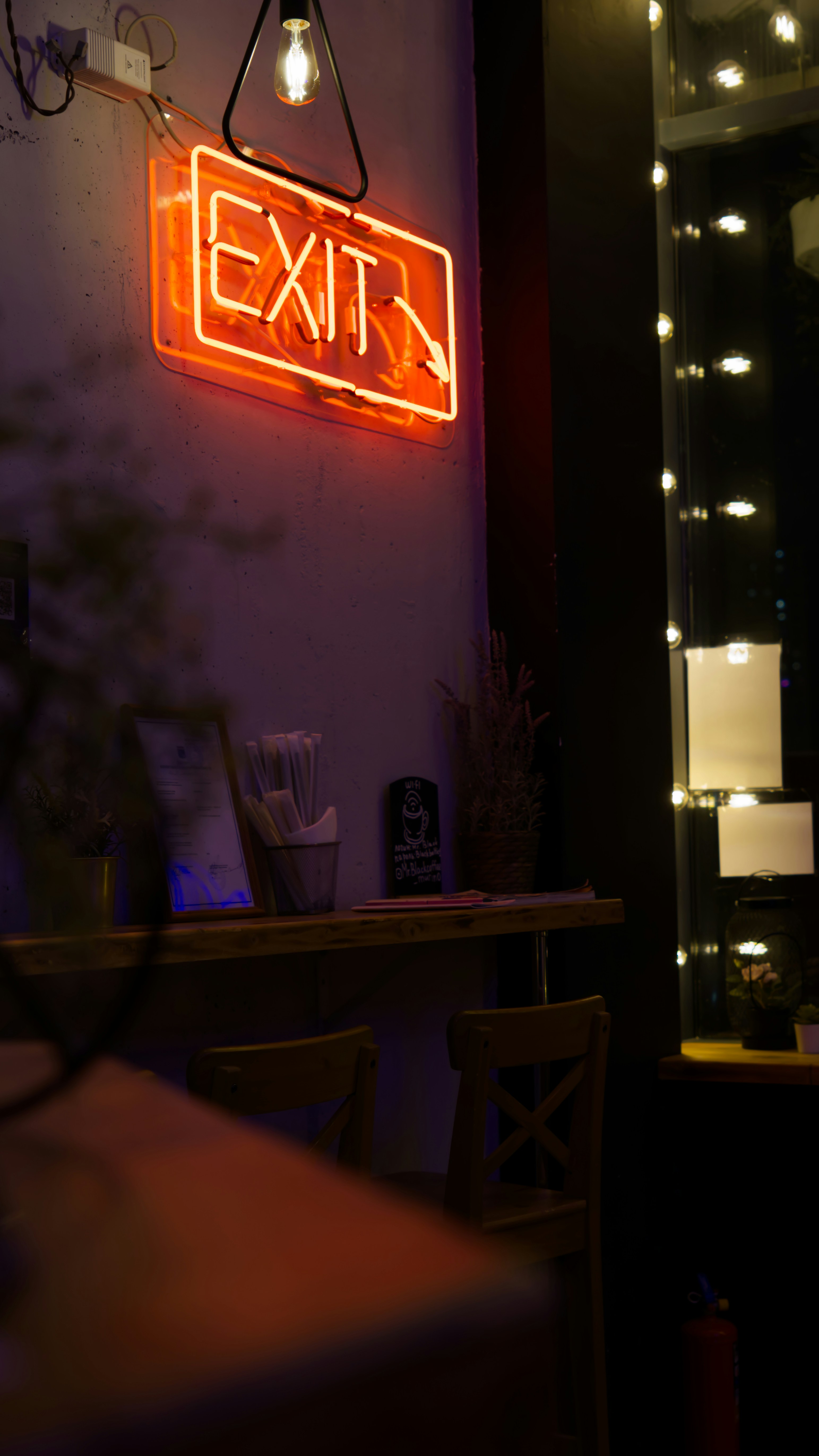 A neon exit sign hanging from the side of a wall photo – Free Saint ...