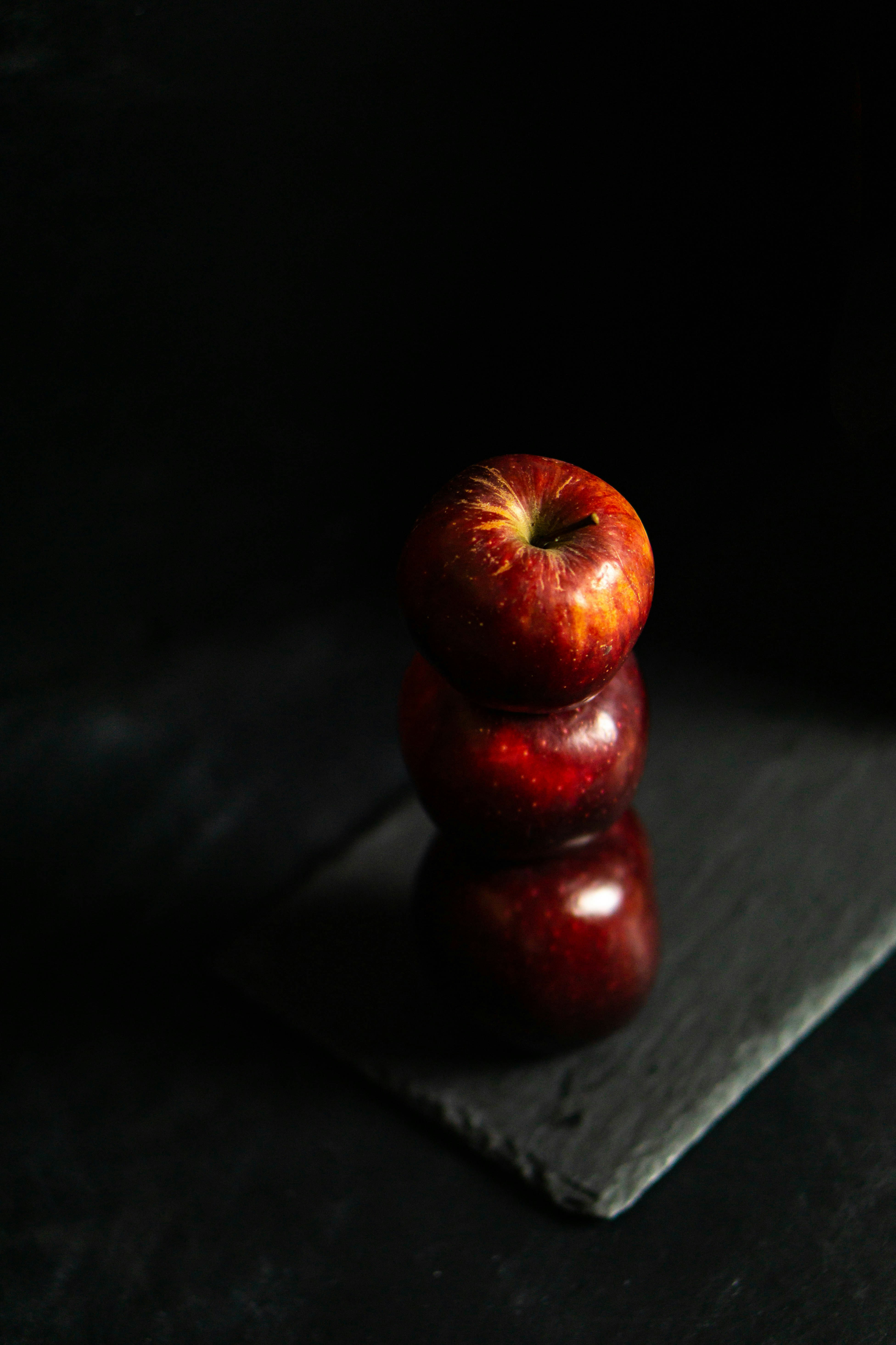 a red apple sitting on top of a piece of paper