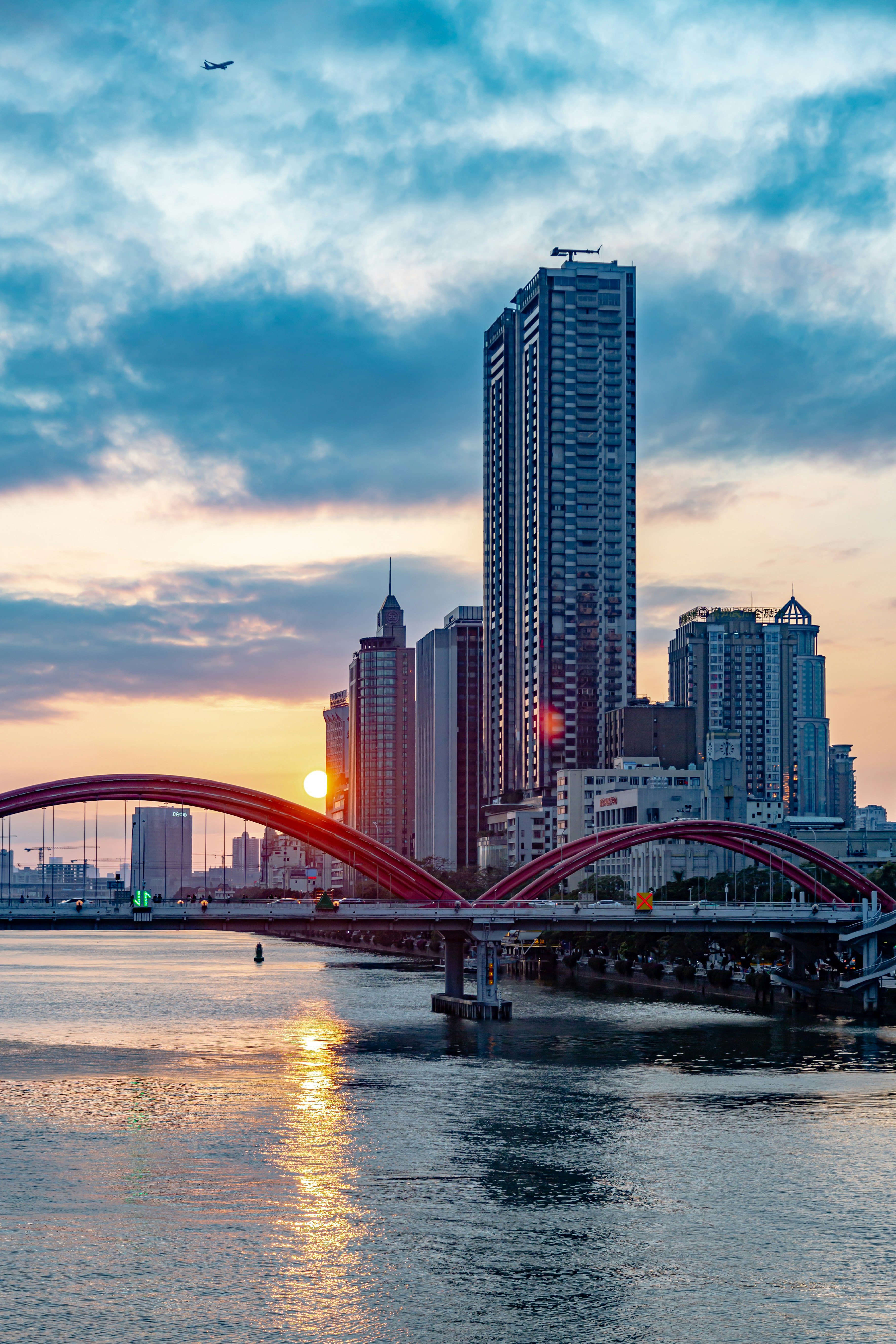 Sunlit Skyline over a Red-arched Bridge at Dusk
