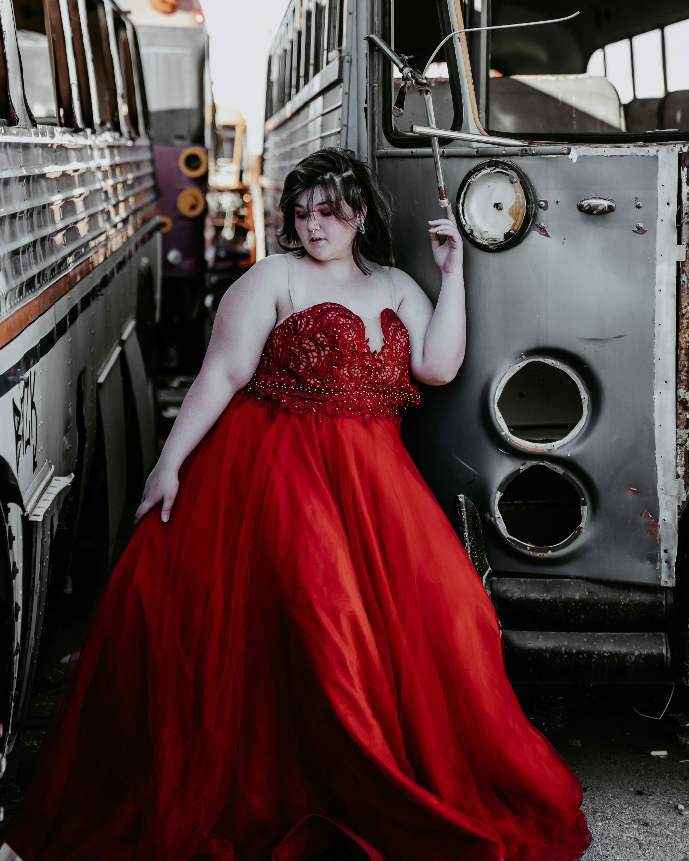 Crimson Gown Between Rusted Giants