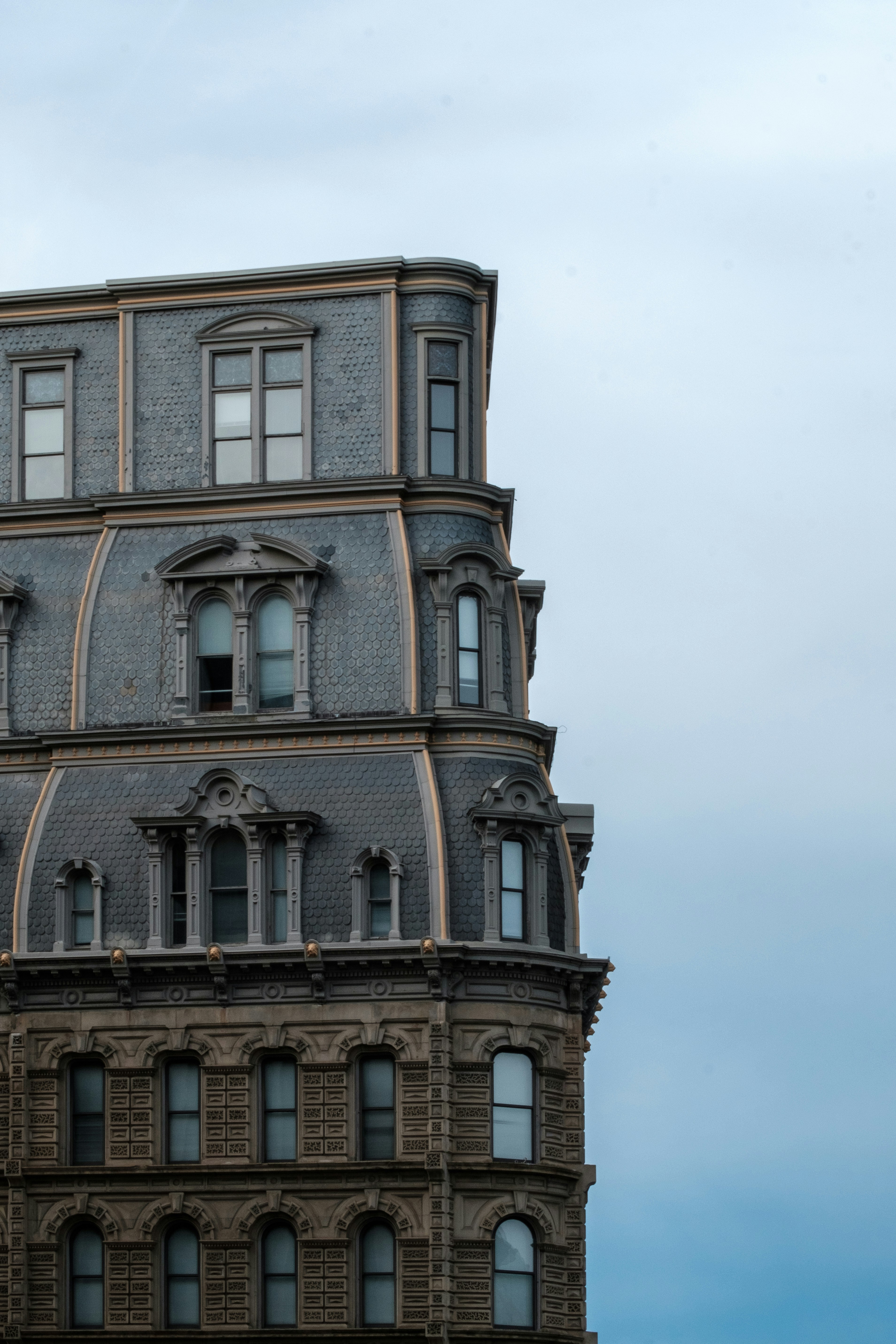 Italianate Corner: Arched Windows and Slate Facade Rise on a Narrow Street