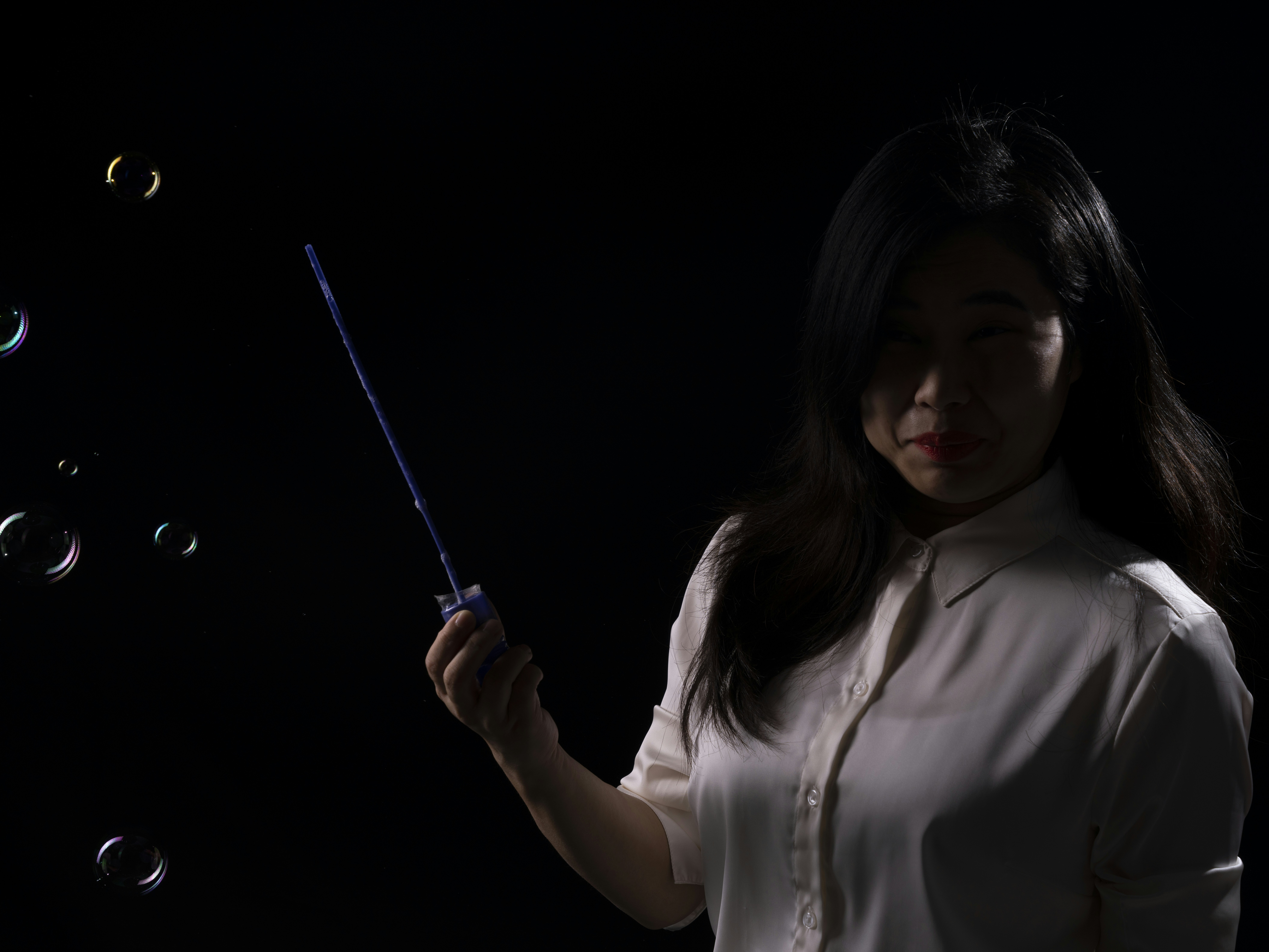 A woman in a white shirt holding a wand photo – Free Human Image on ...