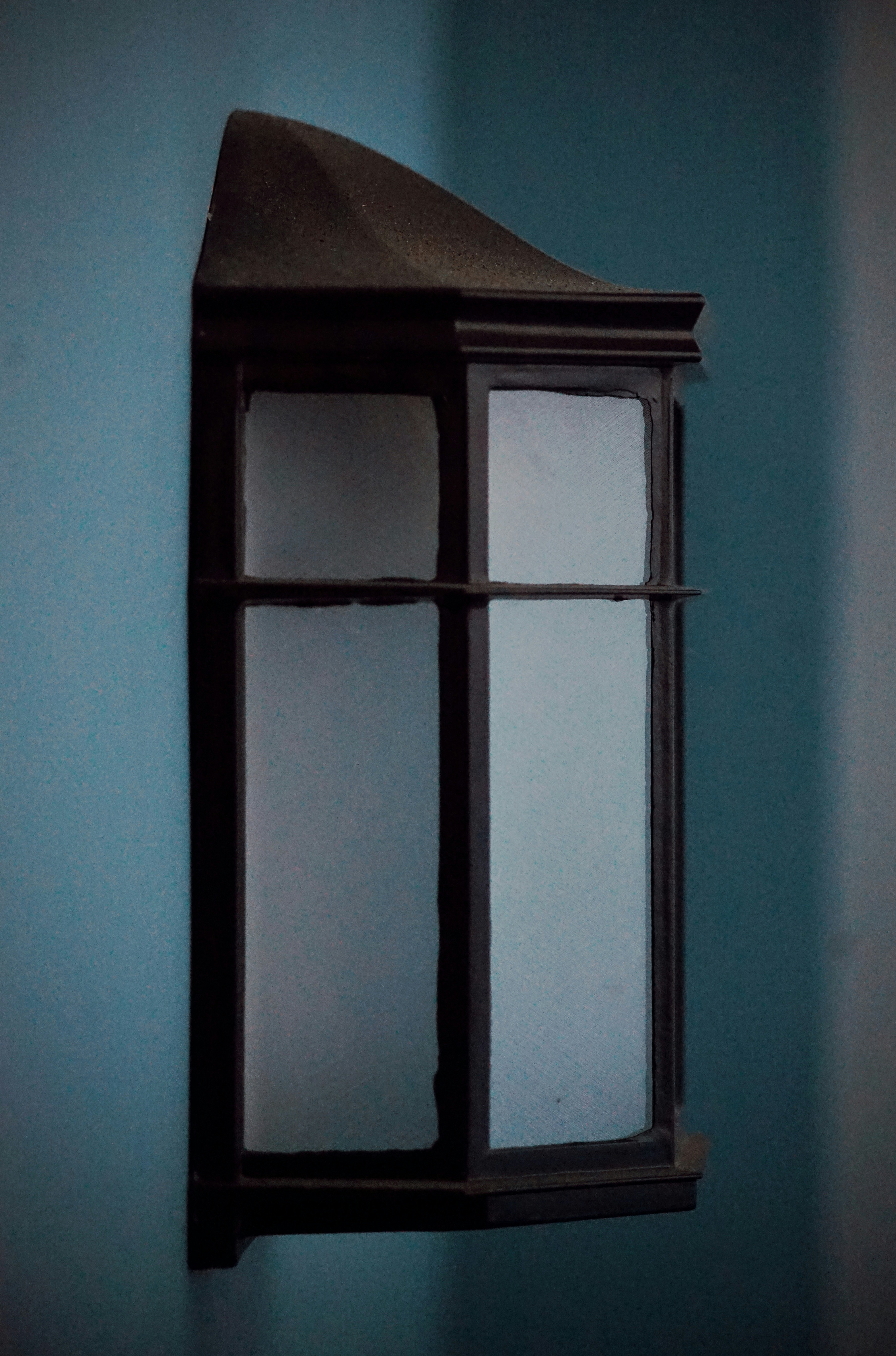 Dimly Lit Lantern Emblem on Teal Wall