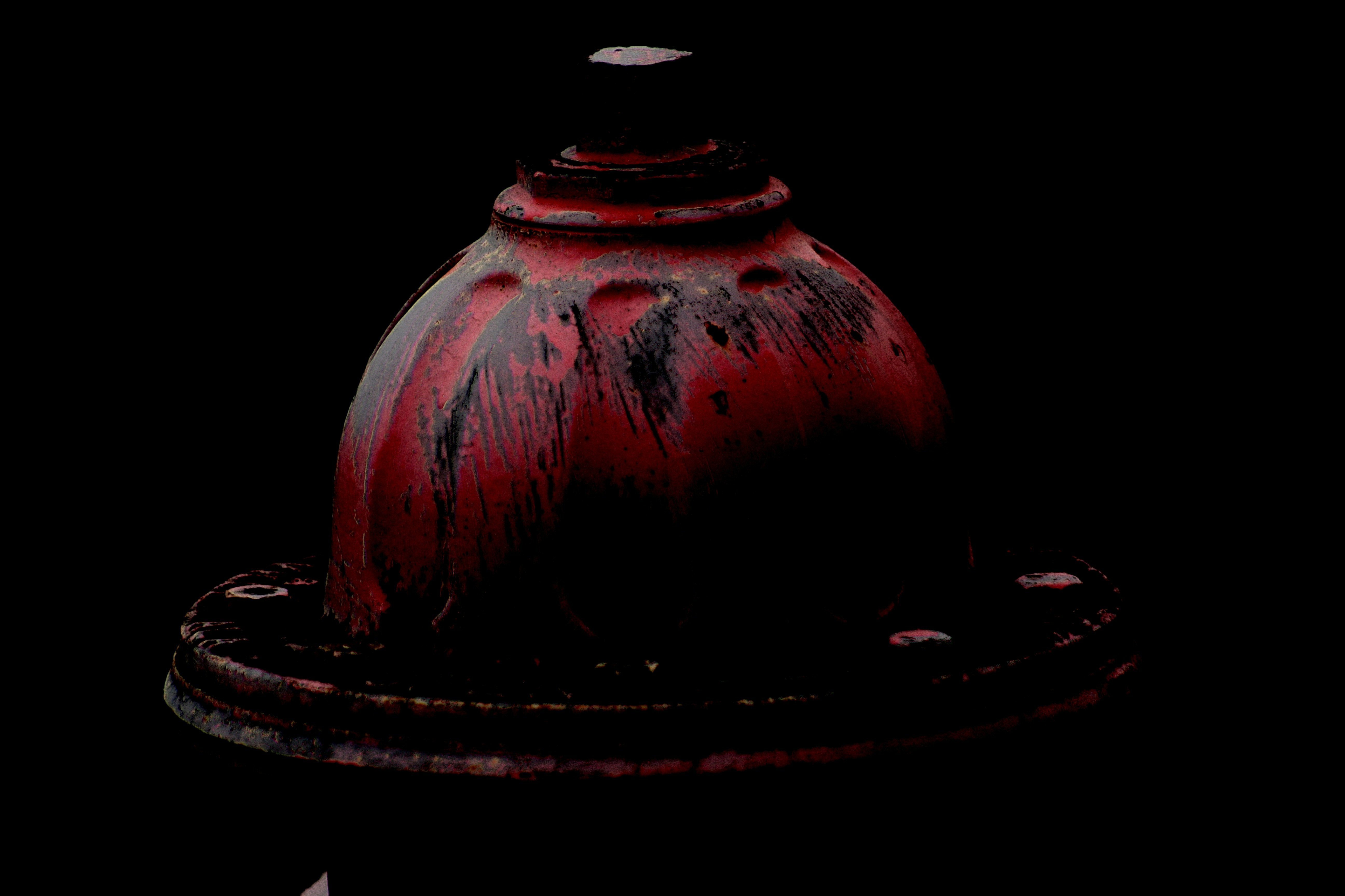 Crimson Cap in the Shadows: A Weathered Spray Can Emerges from Darkness