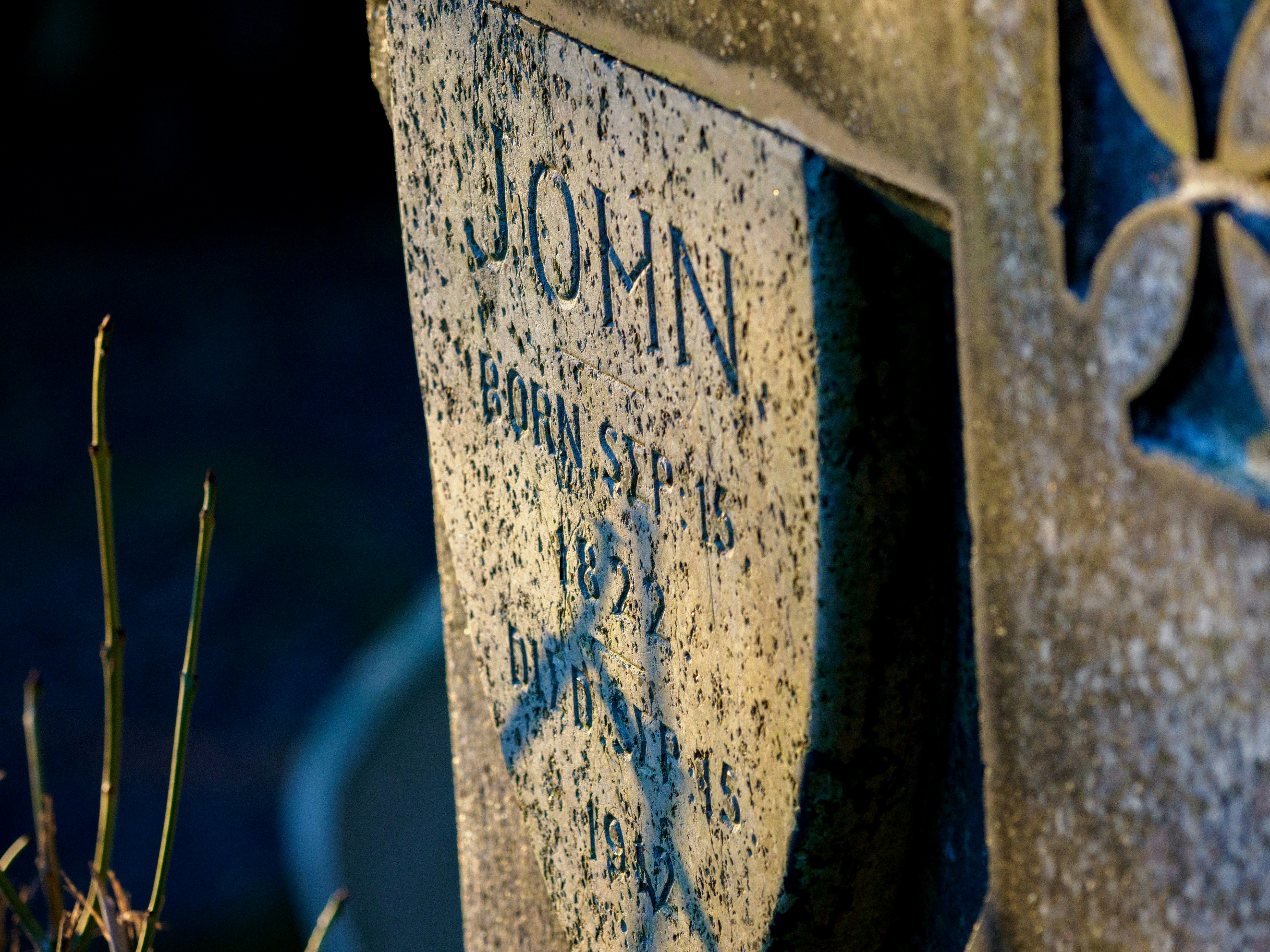 JOMN Stone Carved Gravestone: A Weathered Marker in Soft Graveyard Light