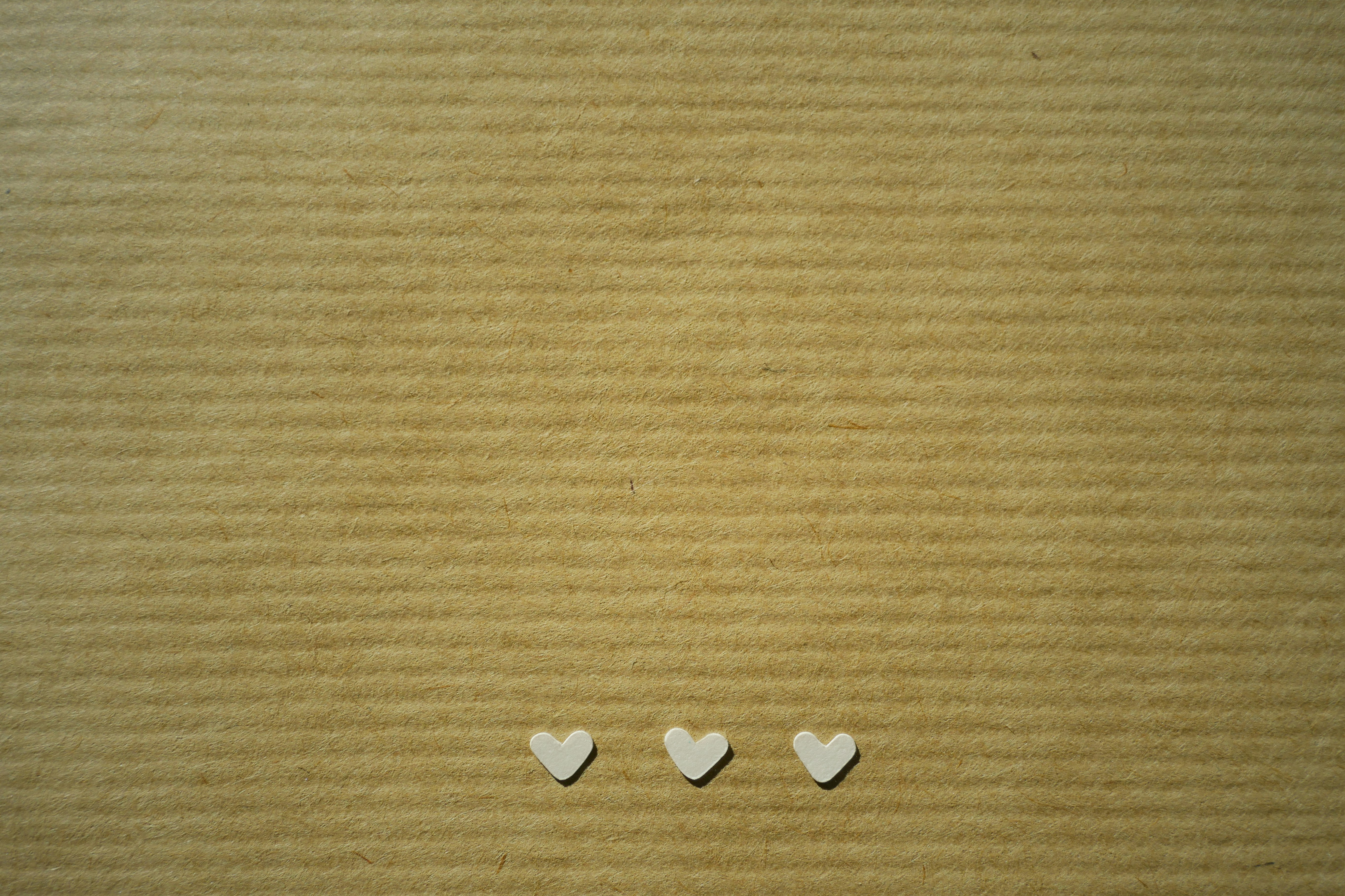 Three small white hearts on a brown cardboard background photo – Free ...