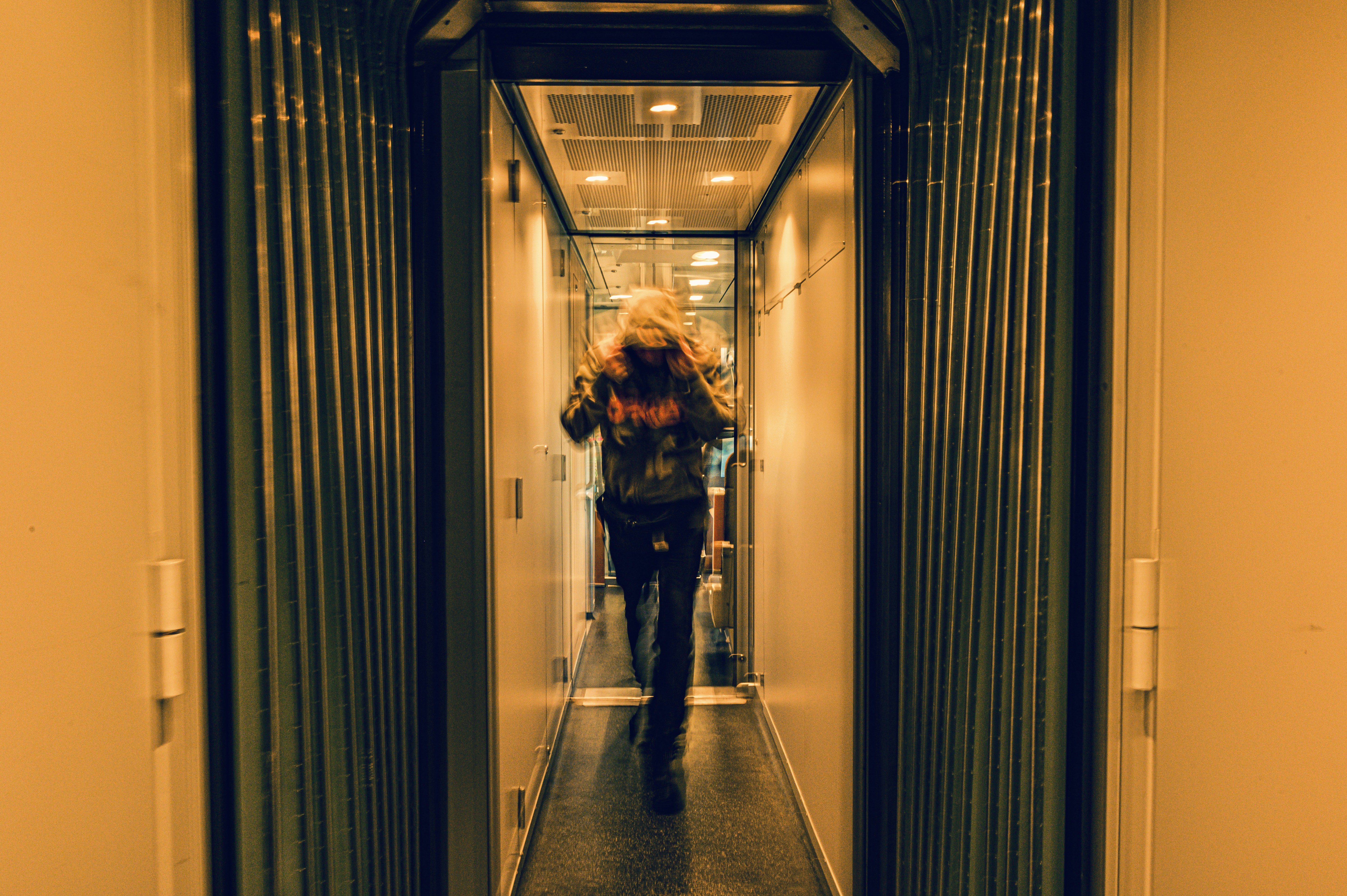 A woman walking down a hallway next to a doorway photo – Free Lighting ...