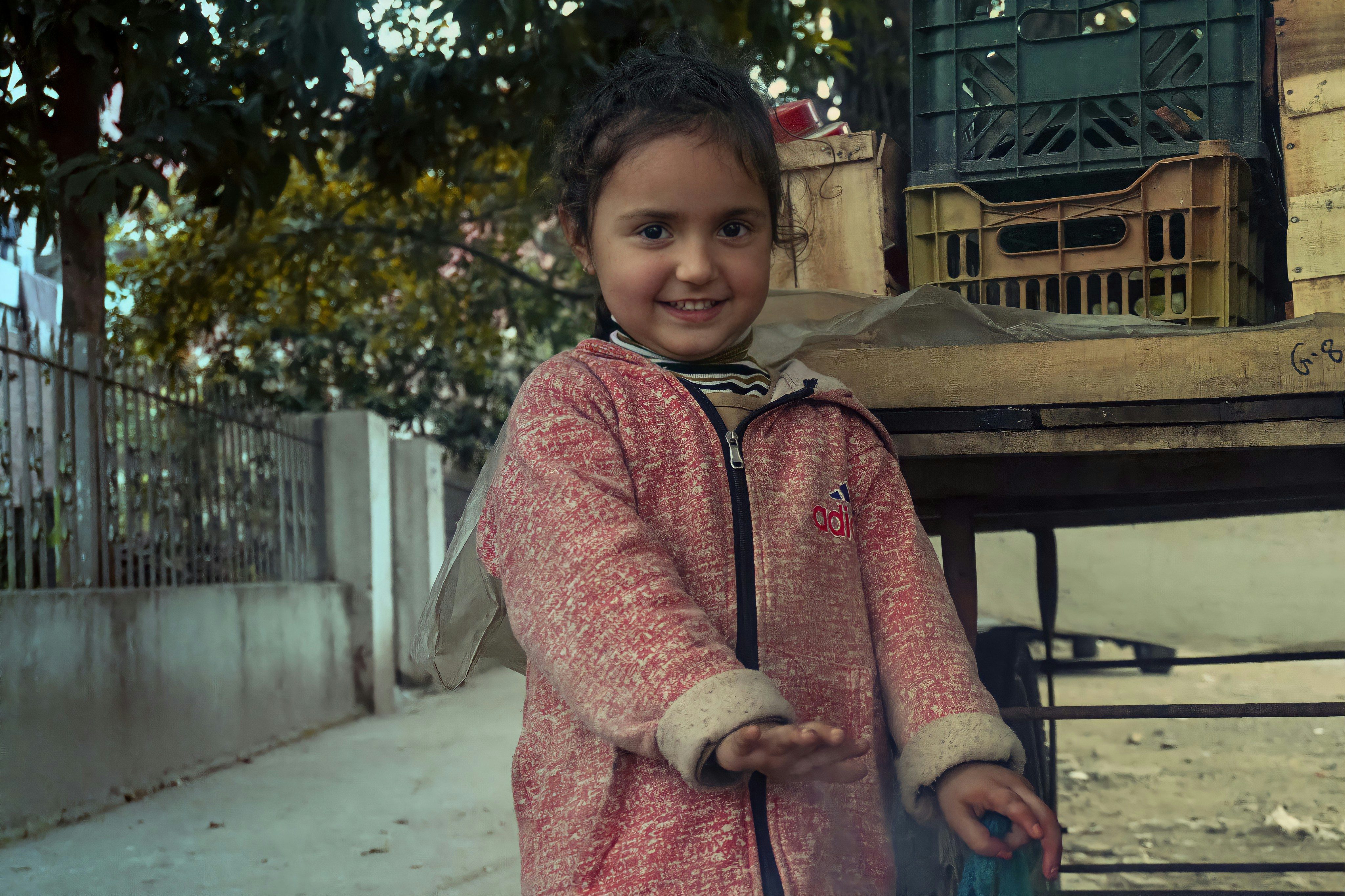 A Pink-Hued Welcome: A young girl's outstretched hand on a sunlit street