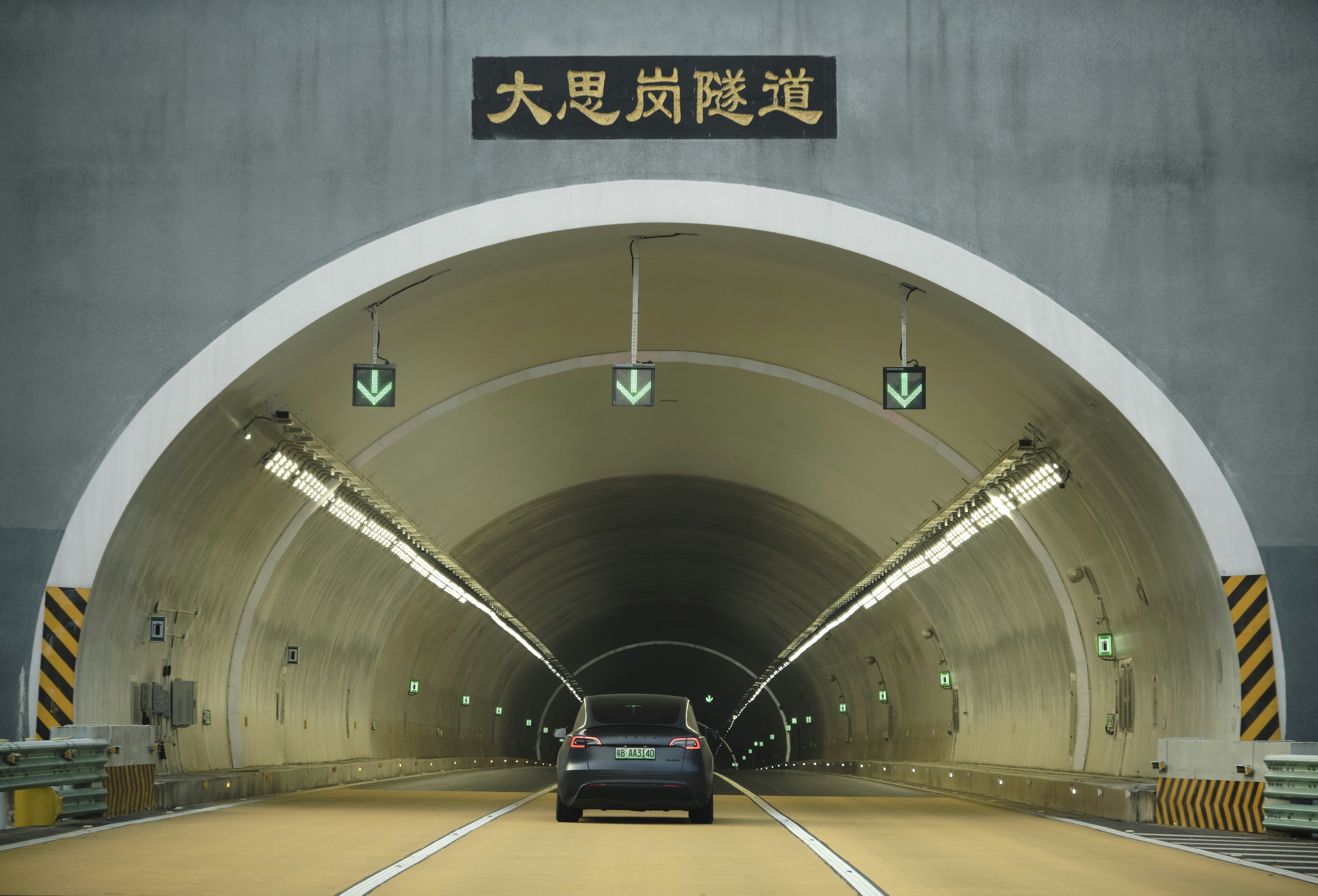 a car driving through a tunnel on a road
