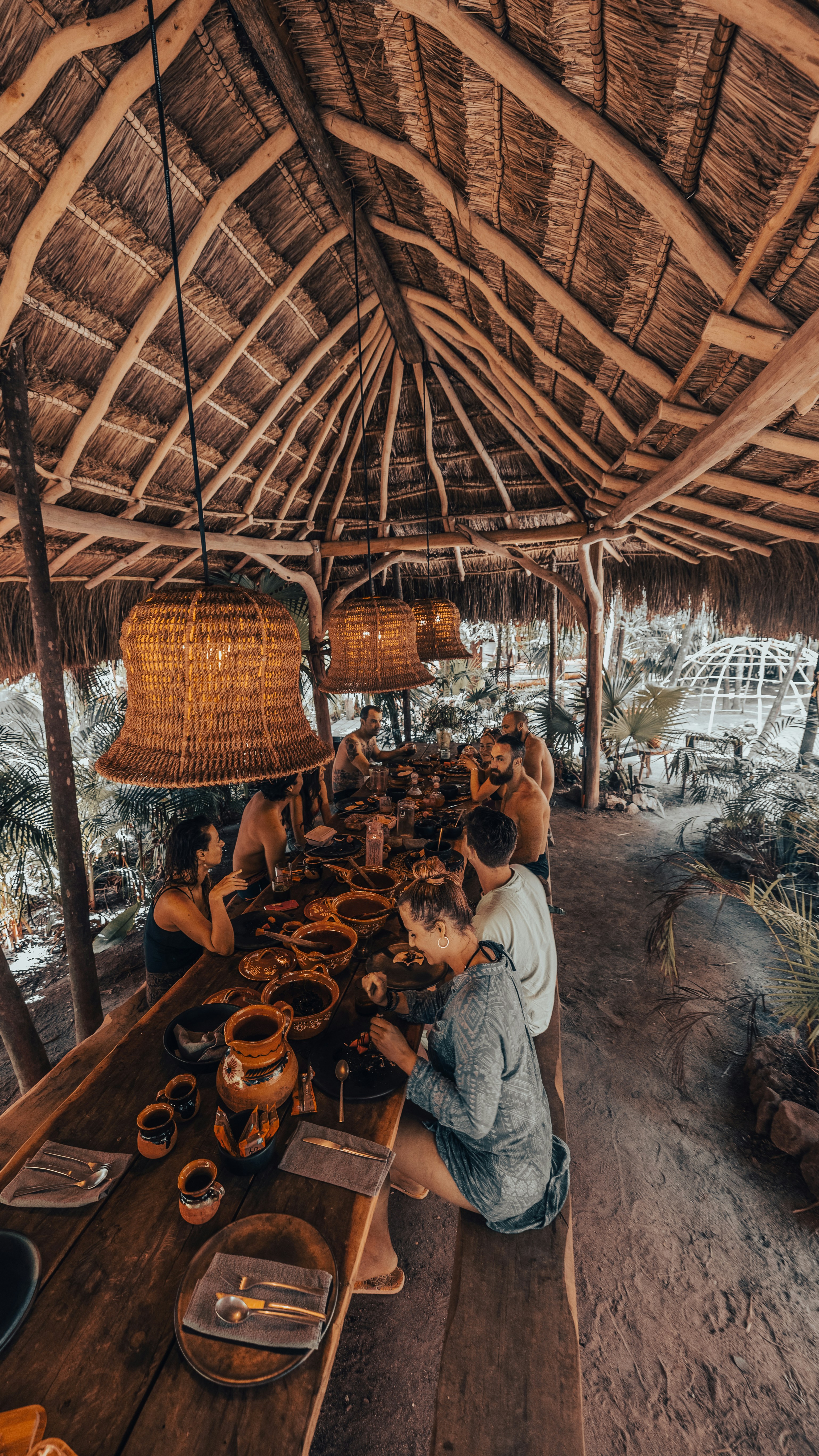 Long Table Under a Thatched Roof: A Shared Meal in Tropical Dusk