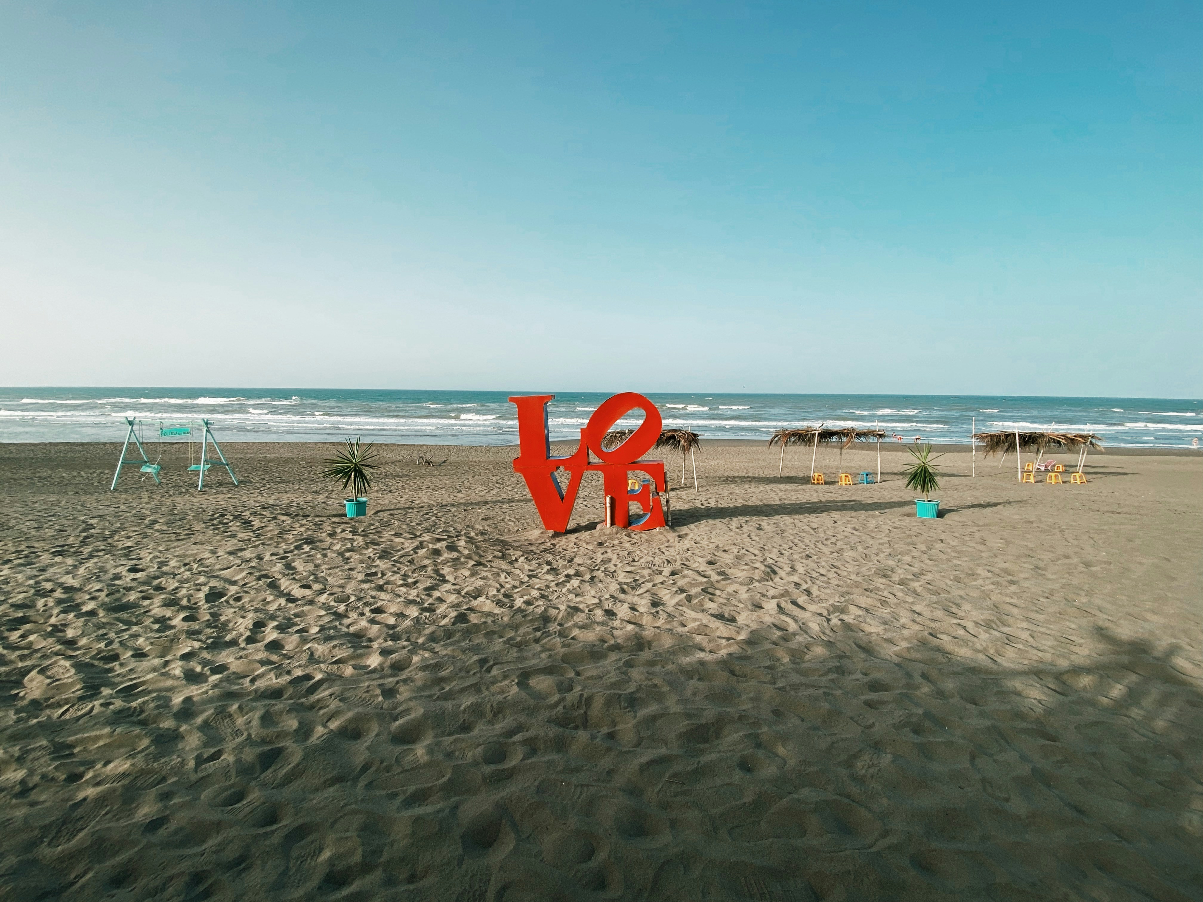Red LOVE Sculpture Anchors a Quiet Beach Scene
