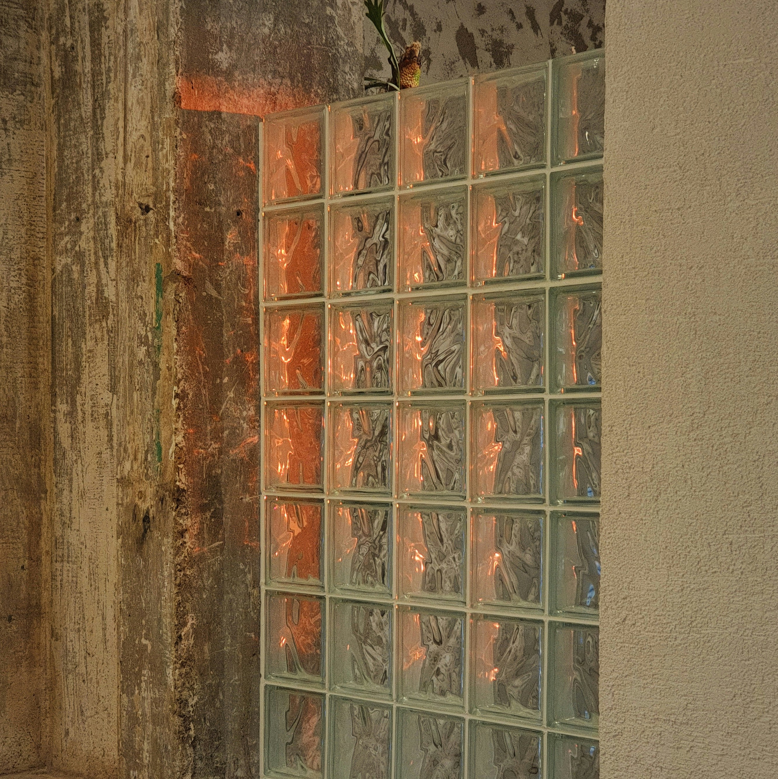 Amber Grid of Glass Blocks Illuminates a Weathered Wall