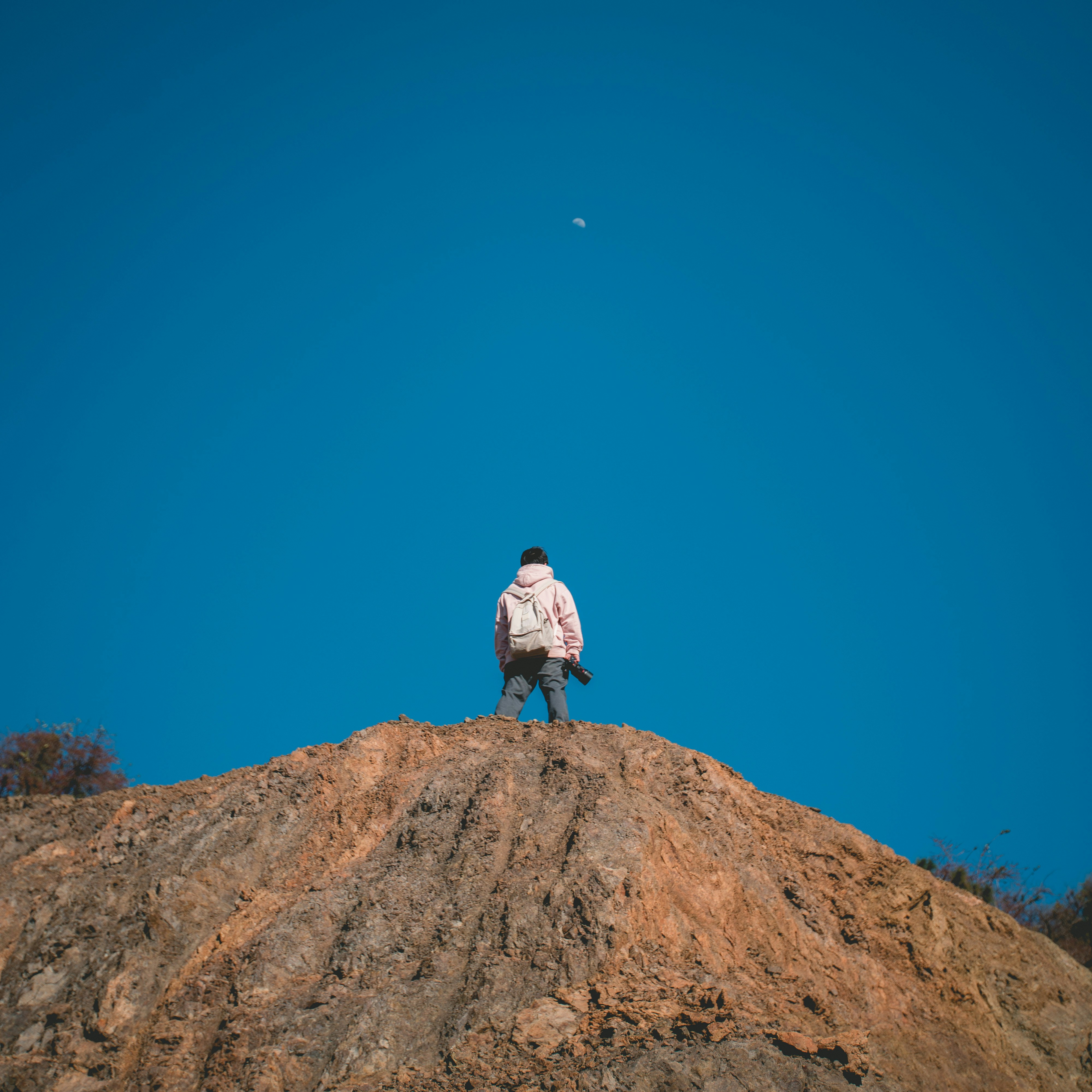 A person standing on top of a large hill photo – Free Nature Image on ...