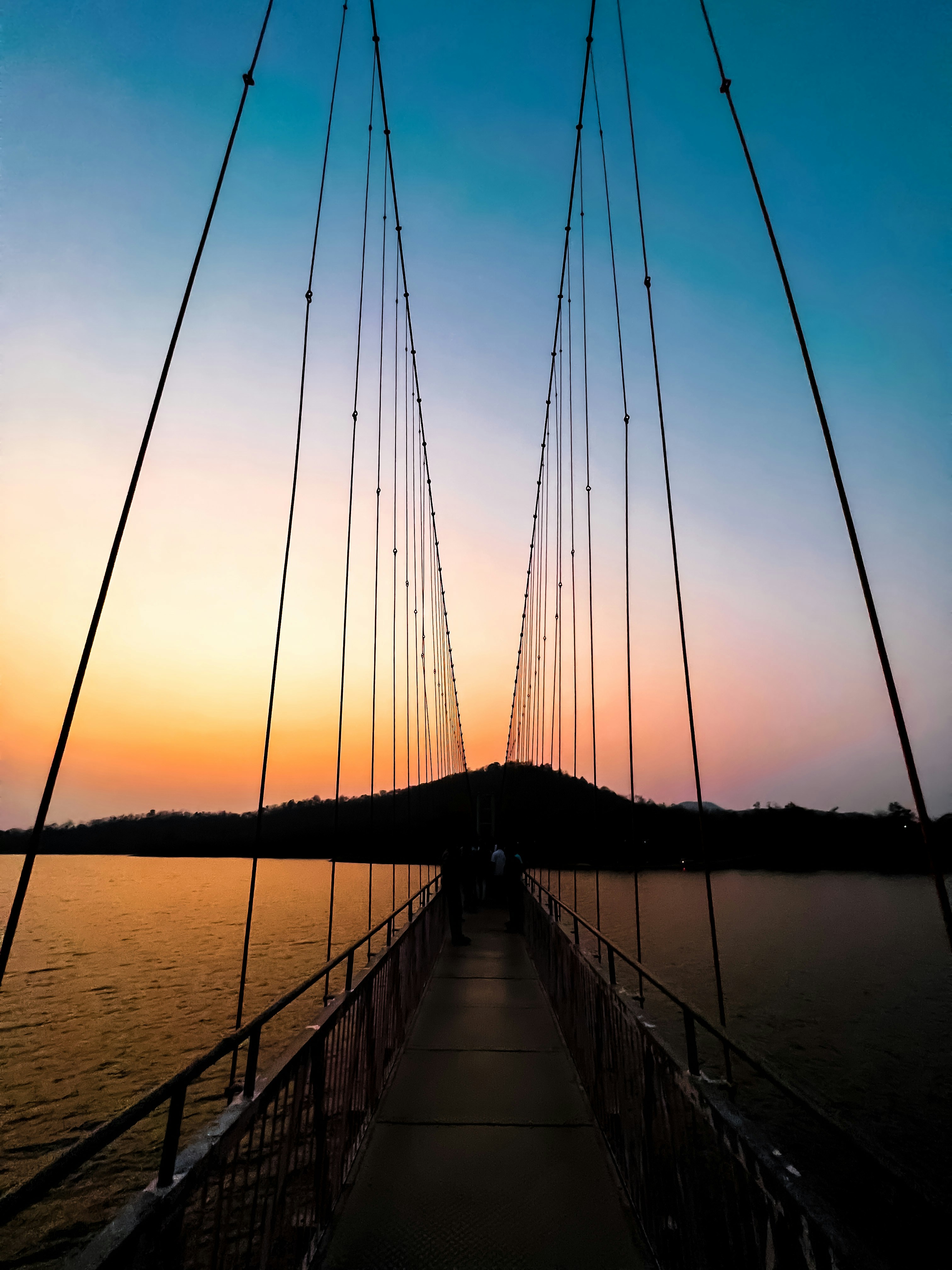 Sunset Convergence on a Cable Bridge: Lines Reaching the Quiet Horizon