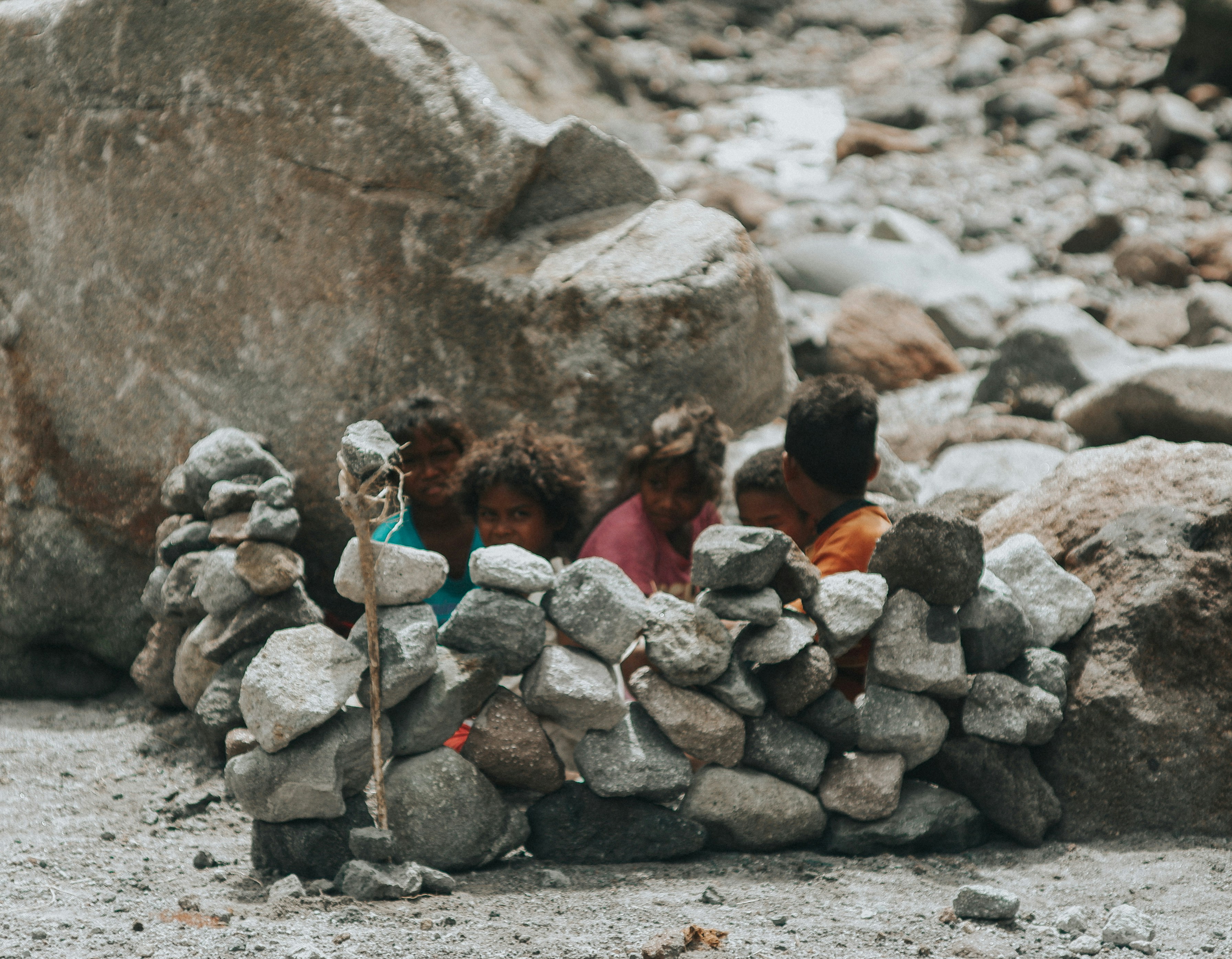 A group of children playing around a pile of rocks photo – Free Mt ...