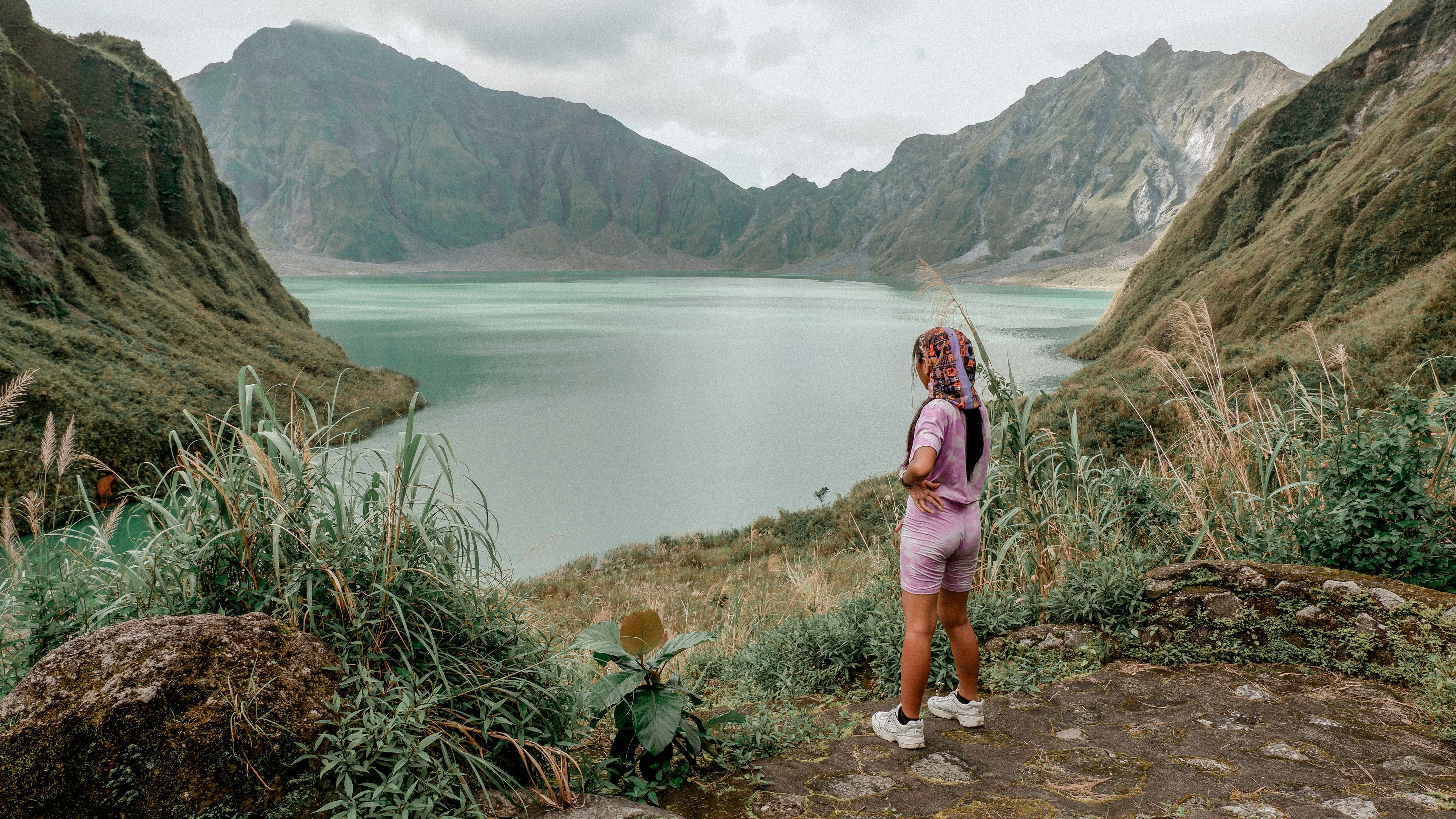 Una persona parada en una colina con vistas a un lago foto – Imagen de ...
