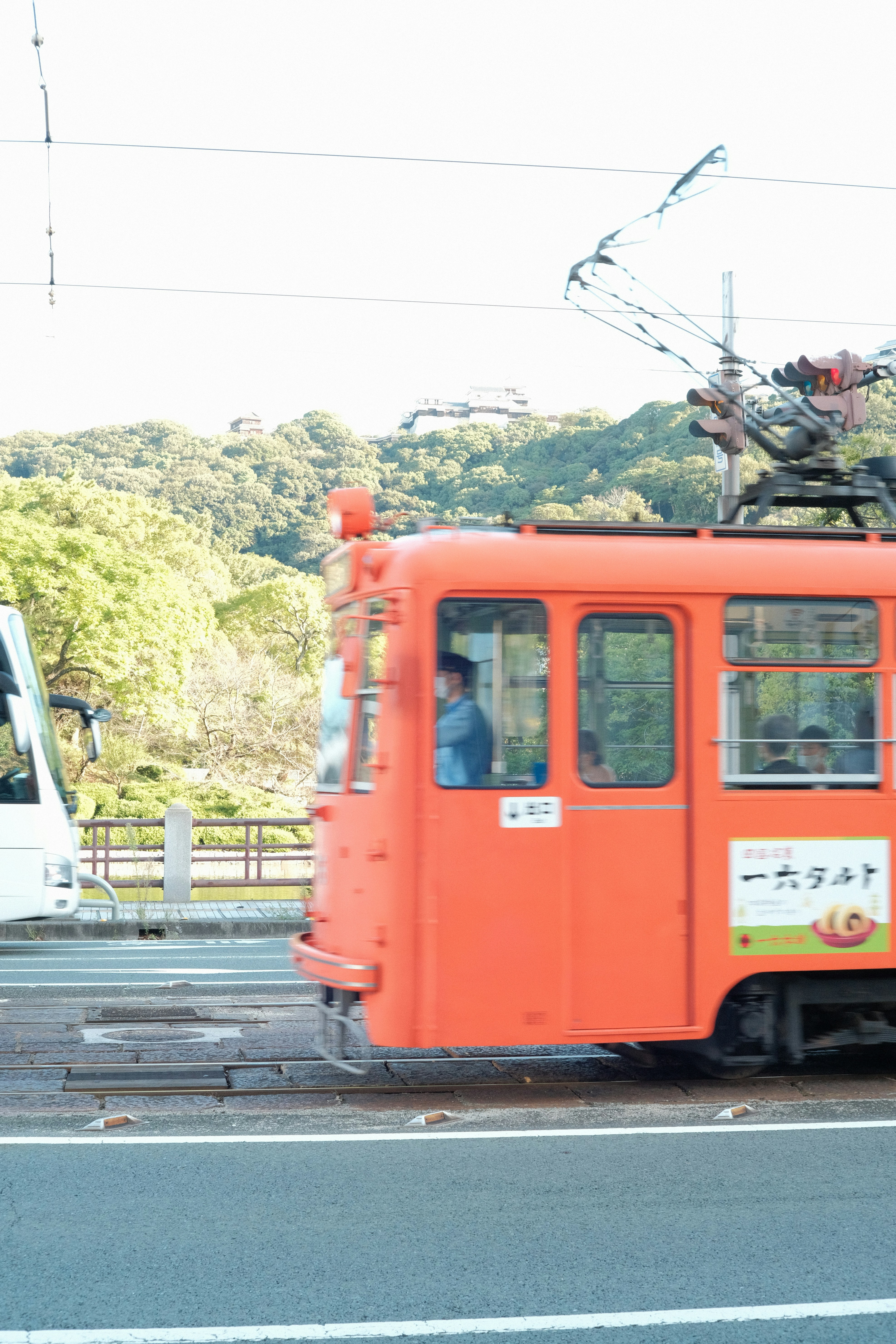 an orange trolley car on a city street