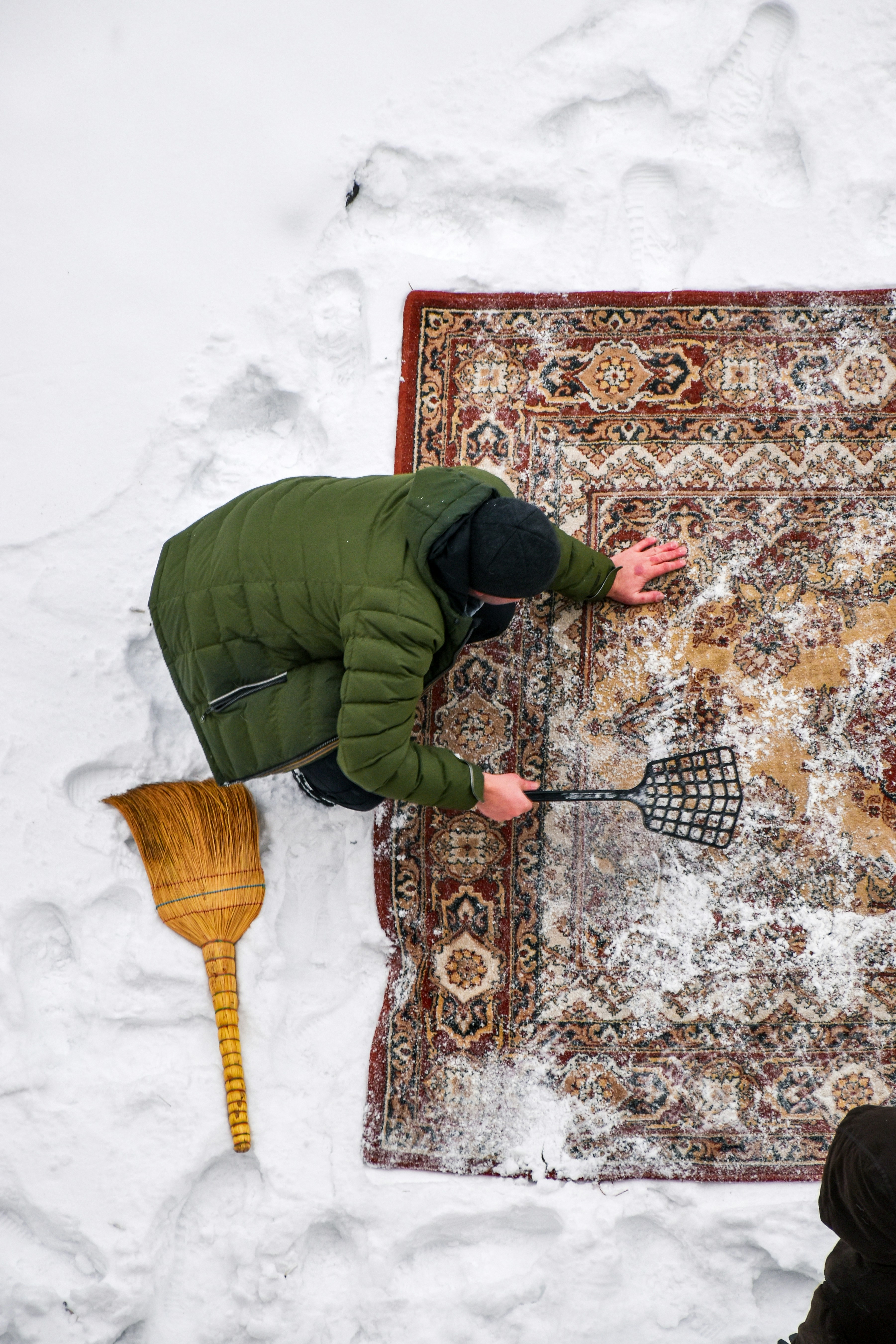 Snowy Workspace: Shovel, Rug, and the Quiet Task of Clearing a Carpeted Path