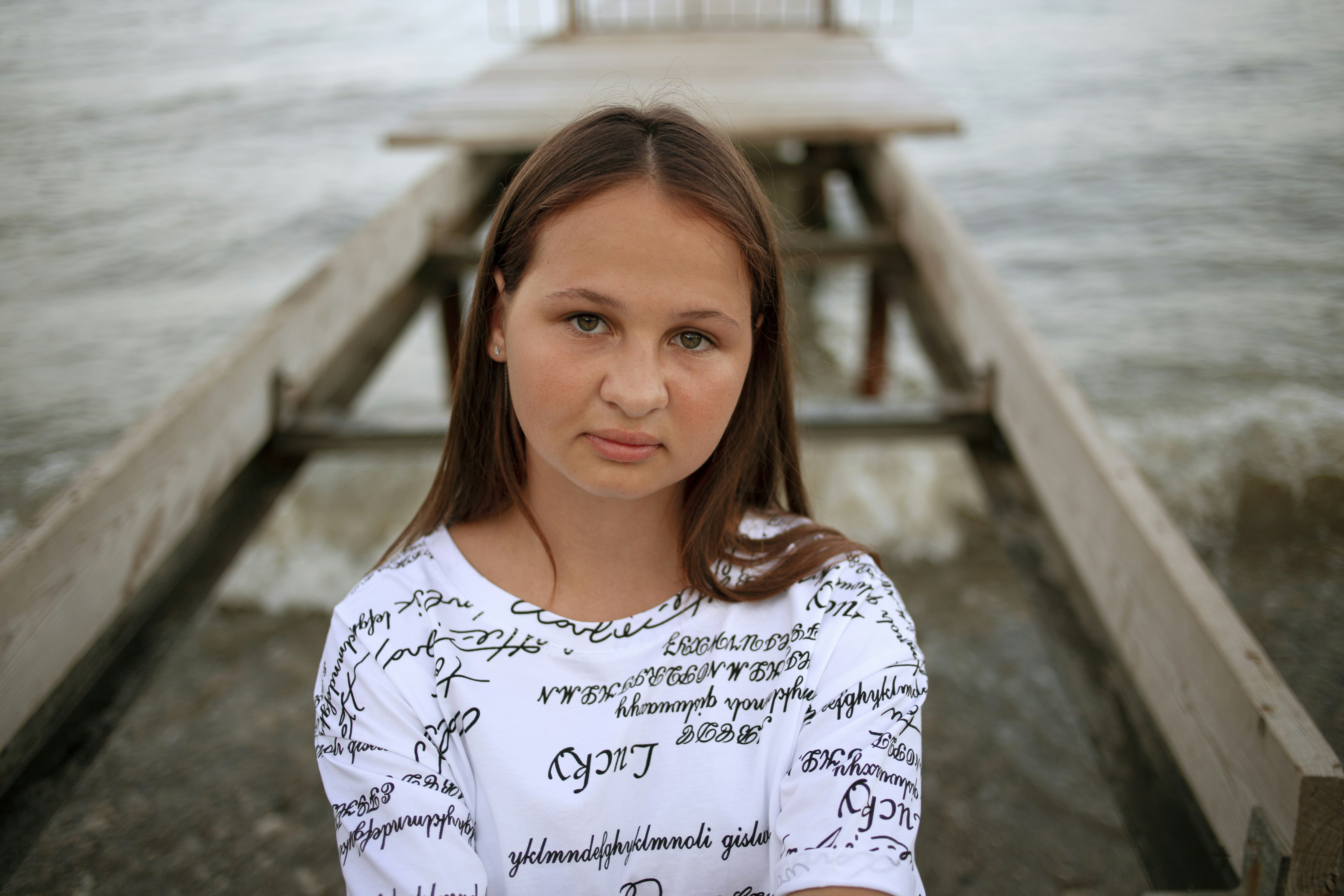 A young girl standing in front of a dock photo – Free Girl Image on ...