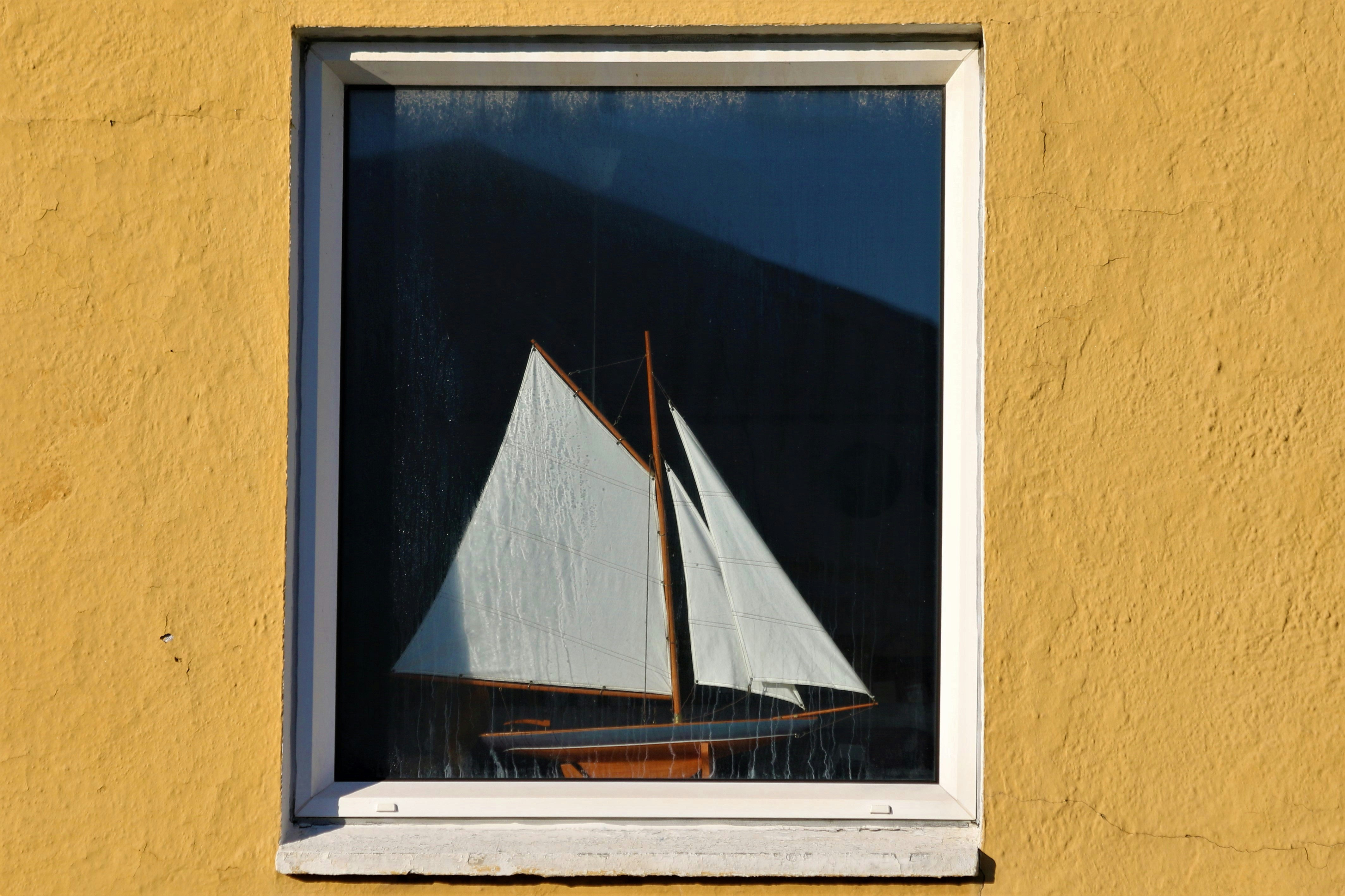 Foto zum Thema Ein Bild von einem Segelboot in einem Fenster ...
