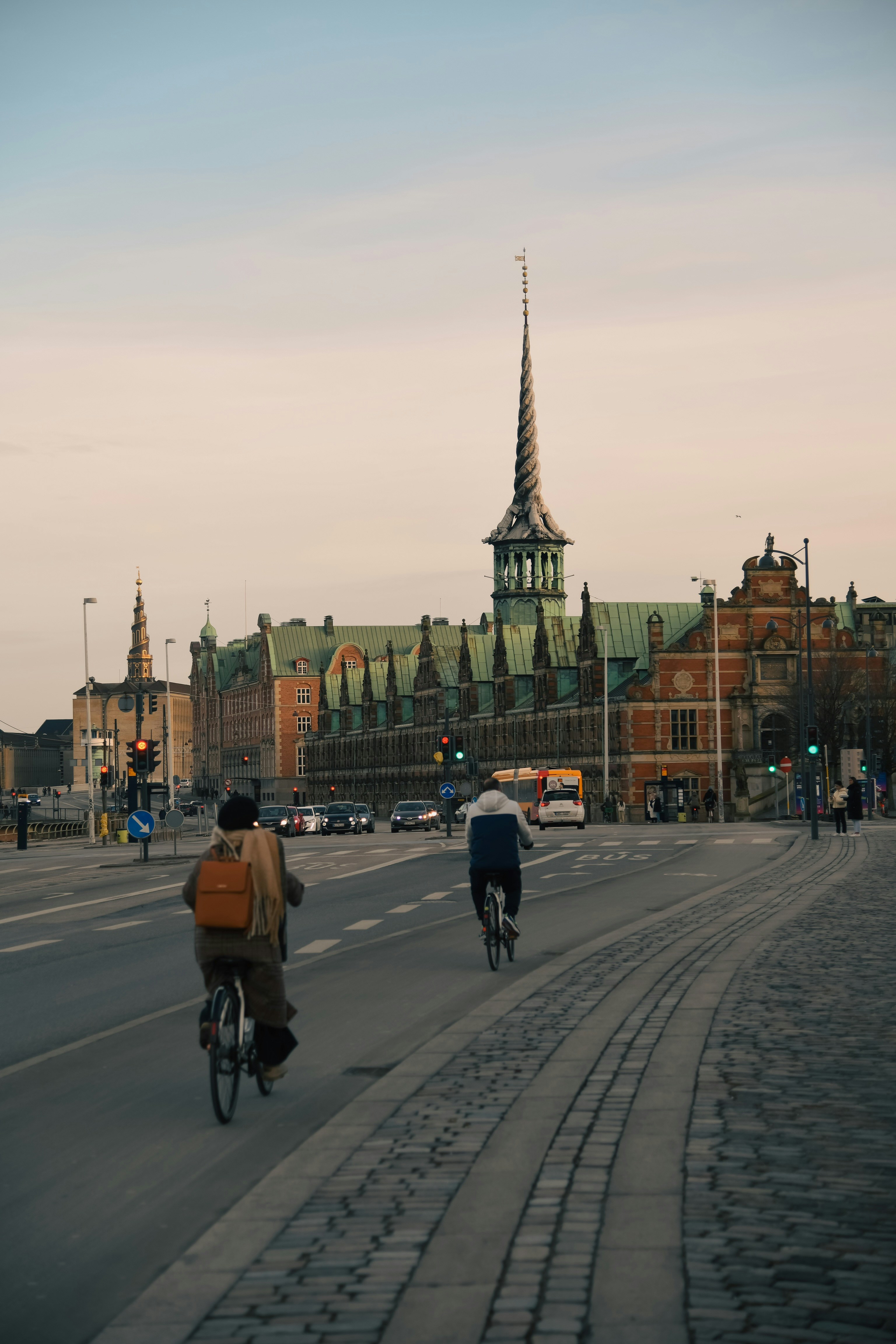 Dusk Over Copper Roofs: Cyclists Glide Along a Historic Boulevard