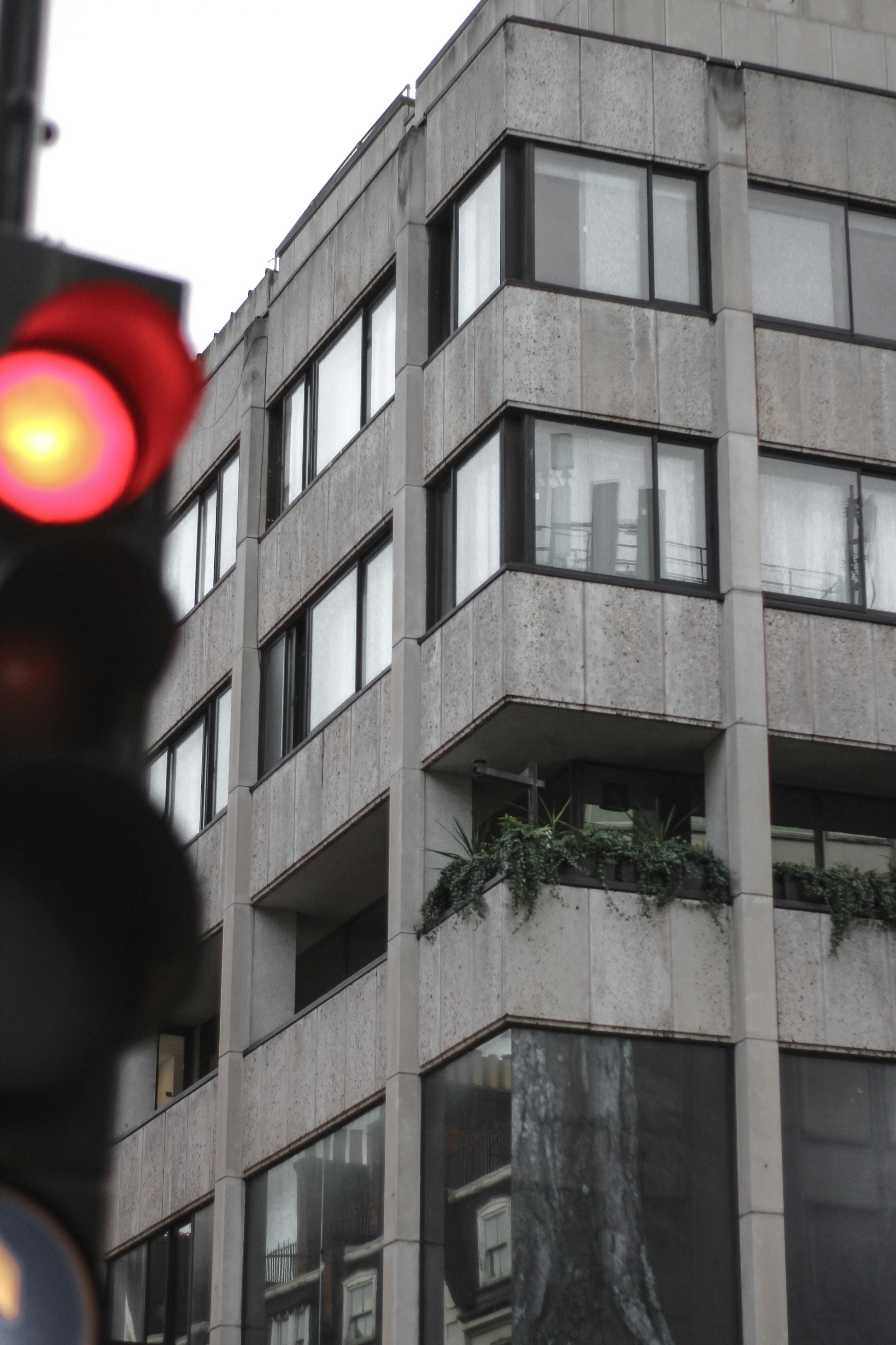 A traffic light in front of a tall building photo – Free Buildings ...