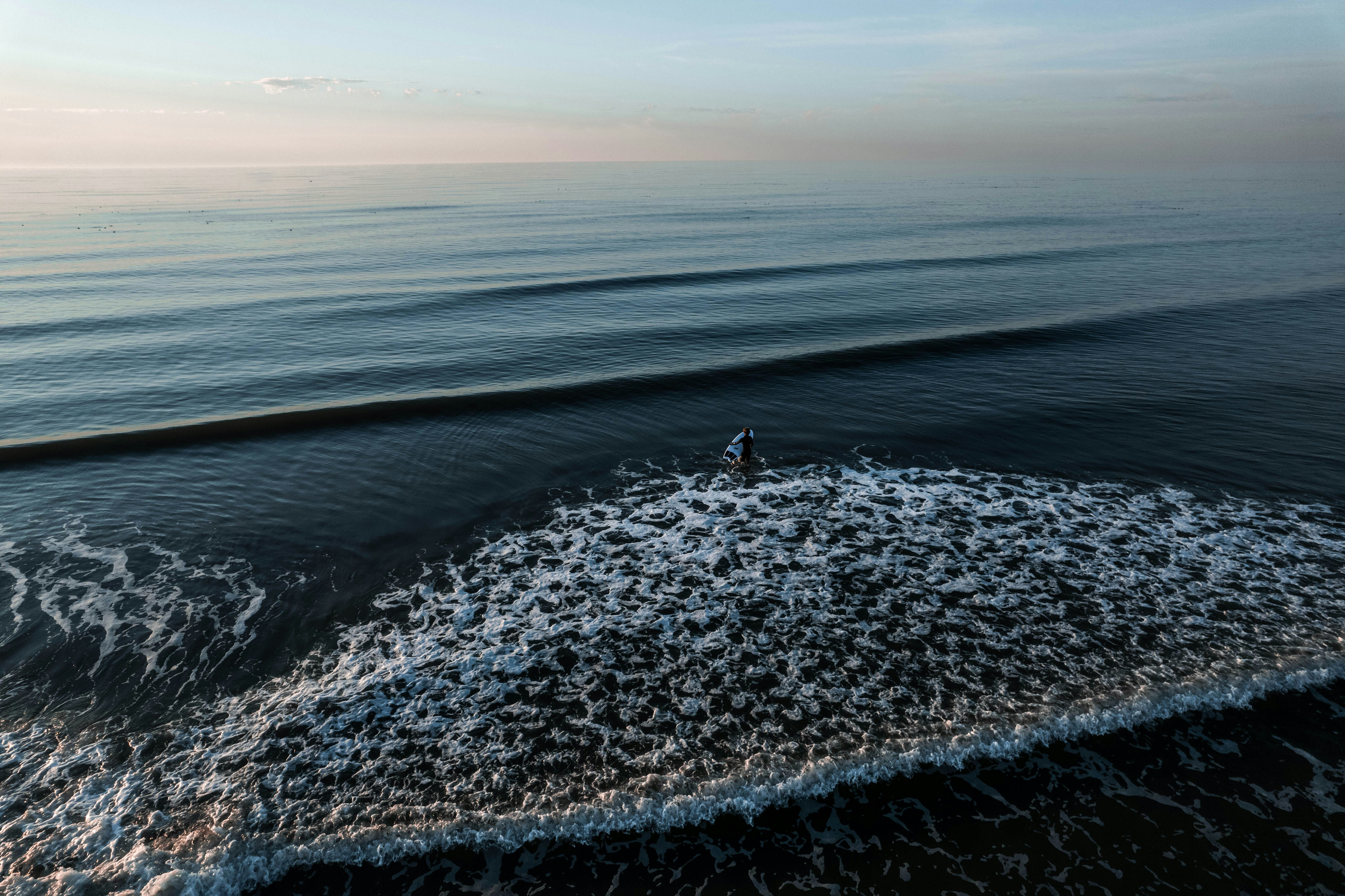 Dawn Break: A lone surfer traces a line between sea and foam