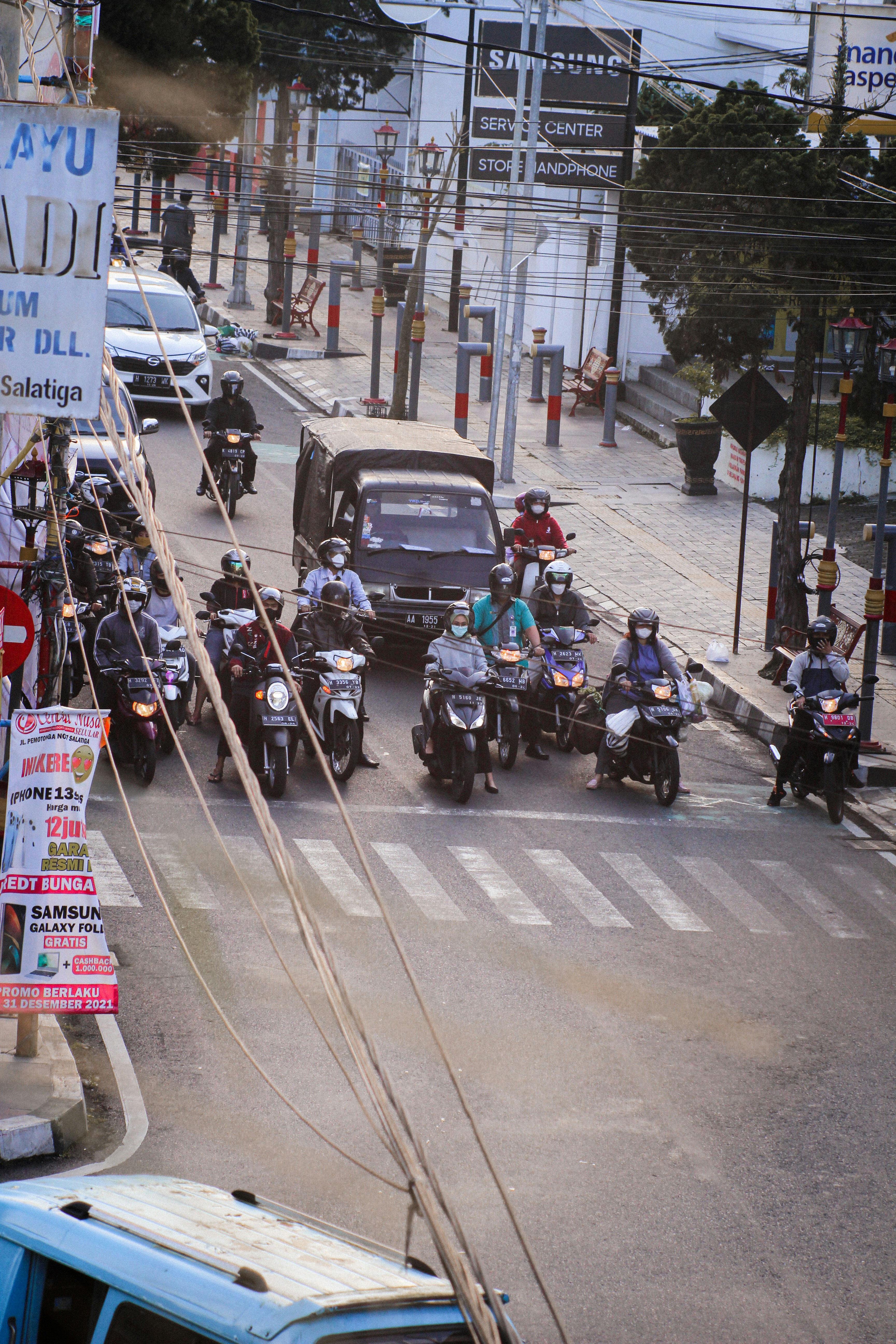 Riders at the Crosswalk: A Tangled Wave of Two-Wheel Traffic