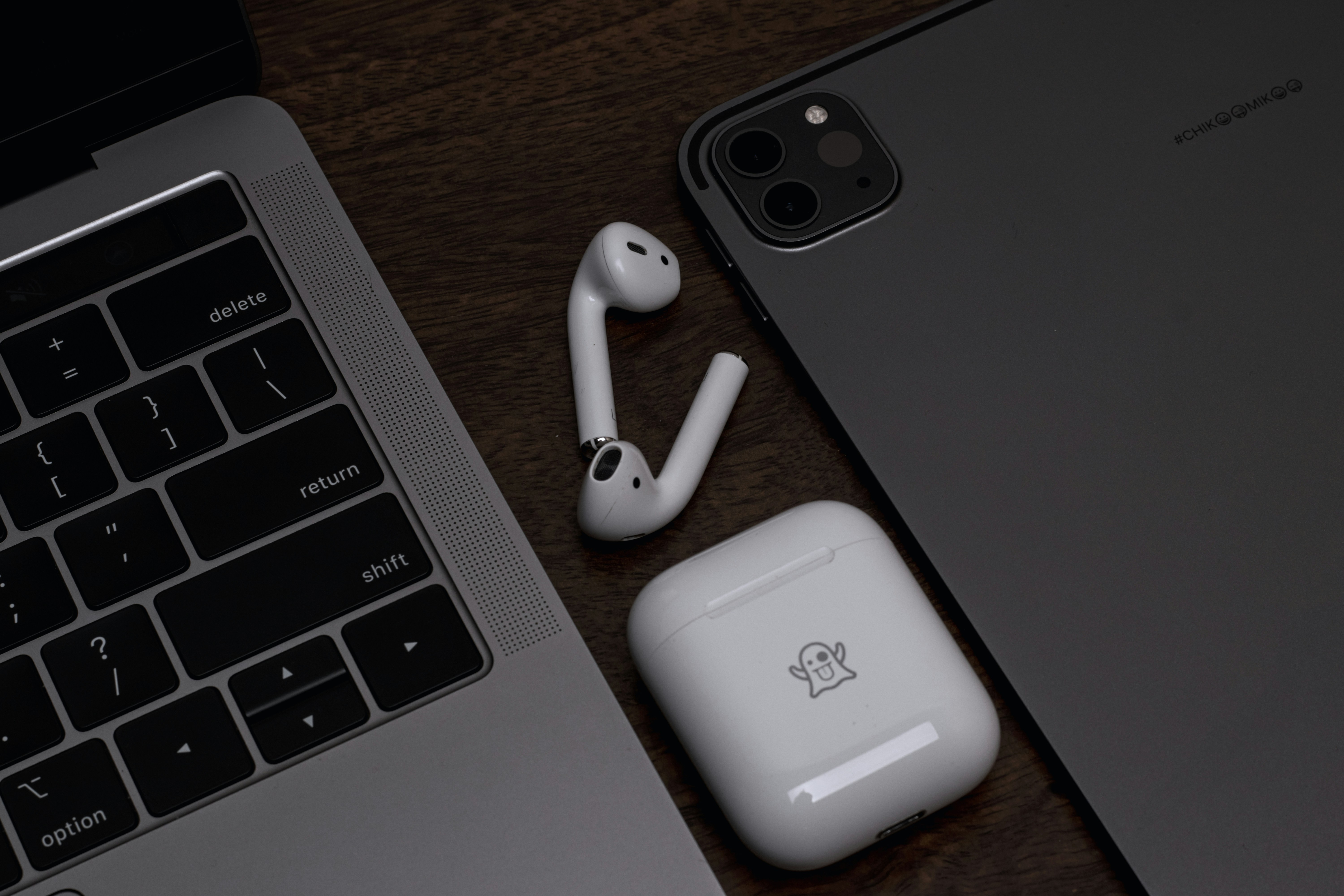 A pair of ear buds sitting next to a laptop photo – Free Product Image ...