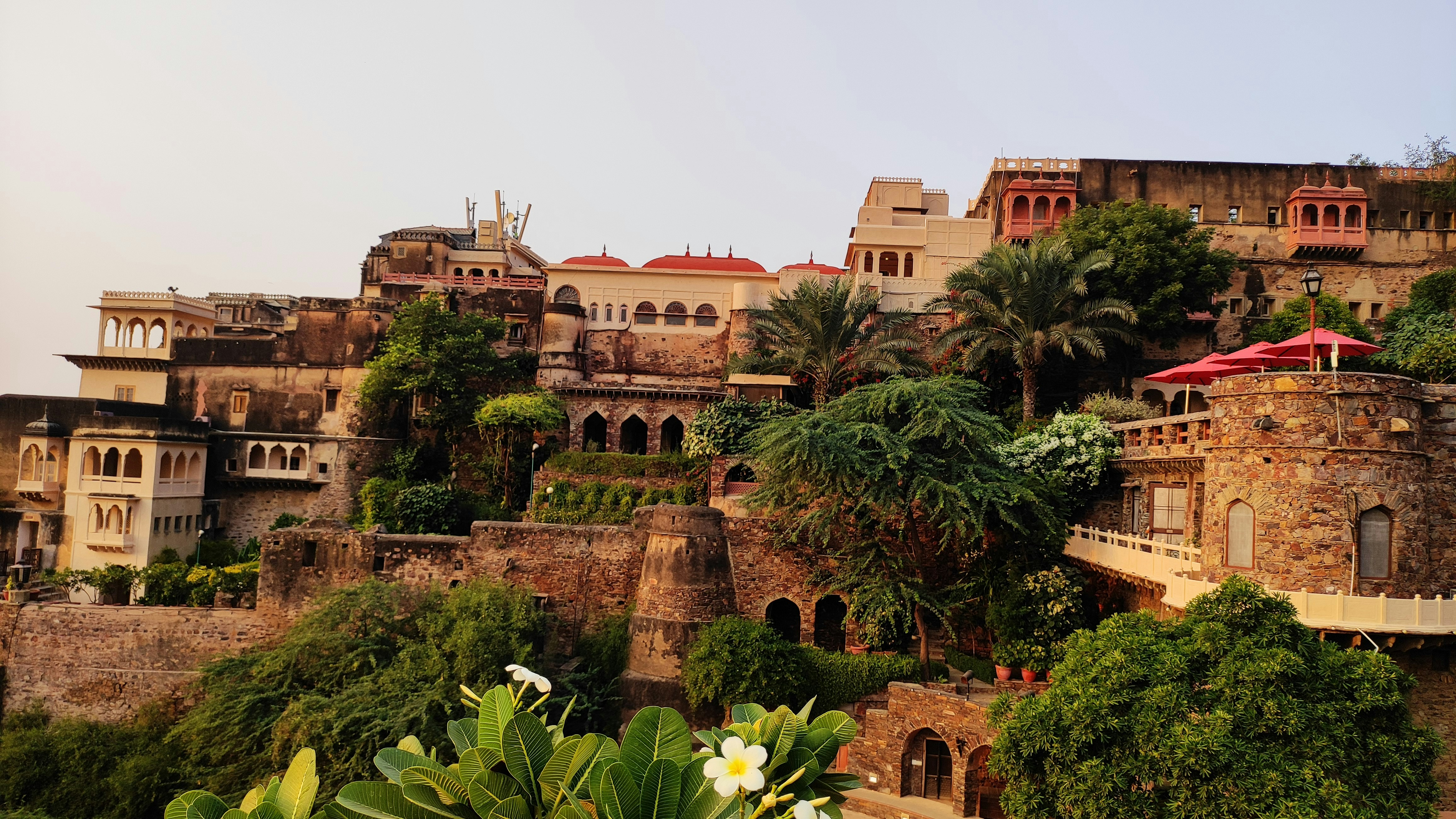 Historic fort complex nestled among lush greenery, showcasing intricate architecture and vibrant vegetation.