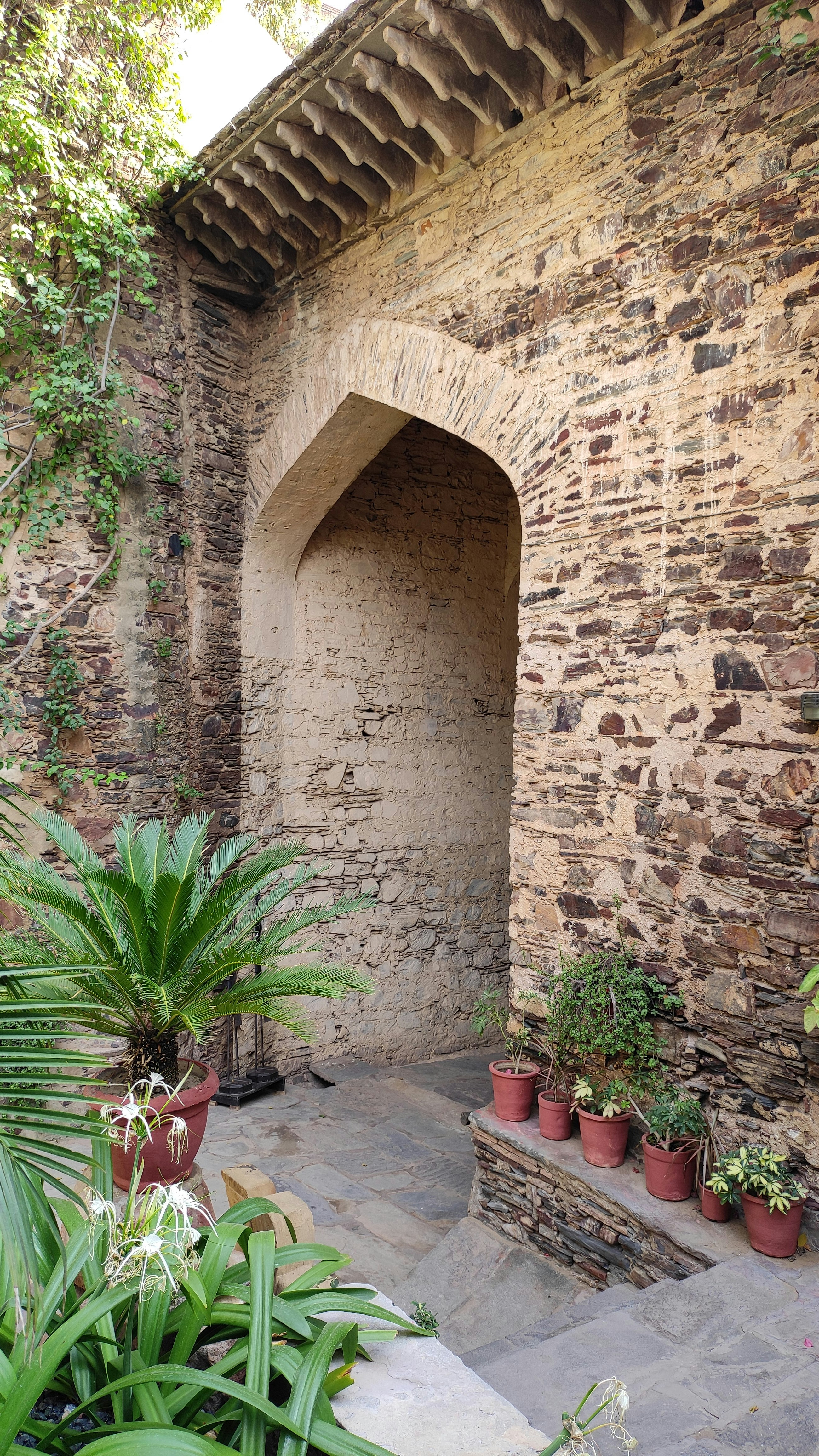 a stone building with potted plants in front of it