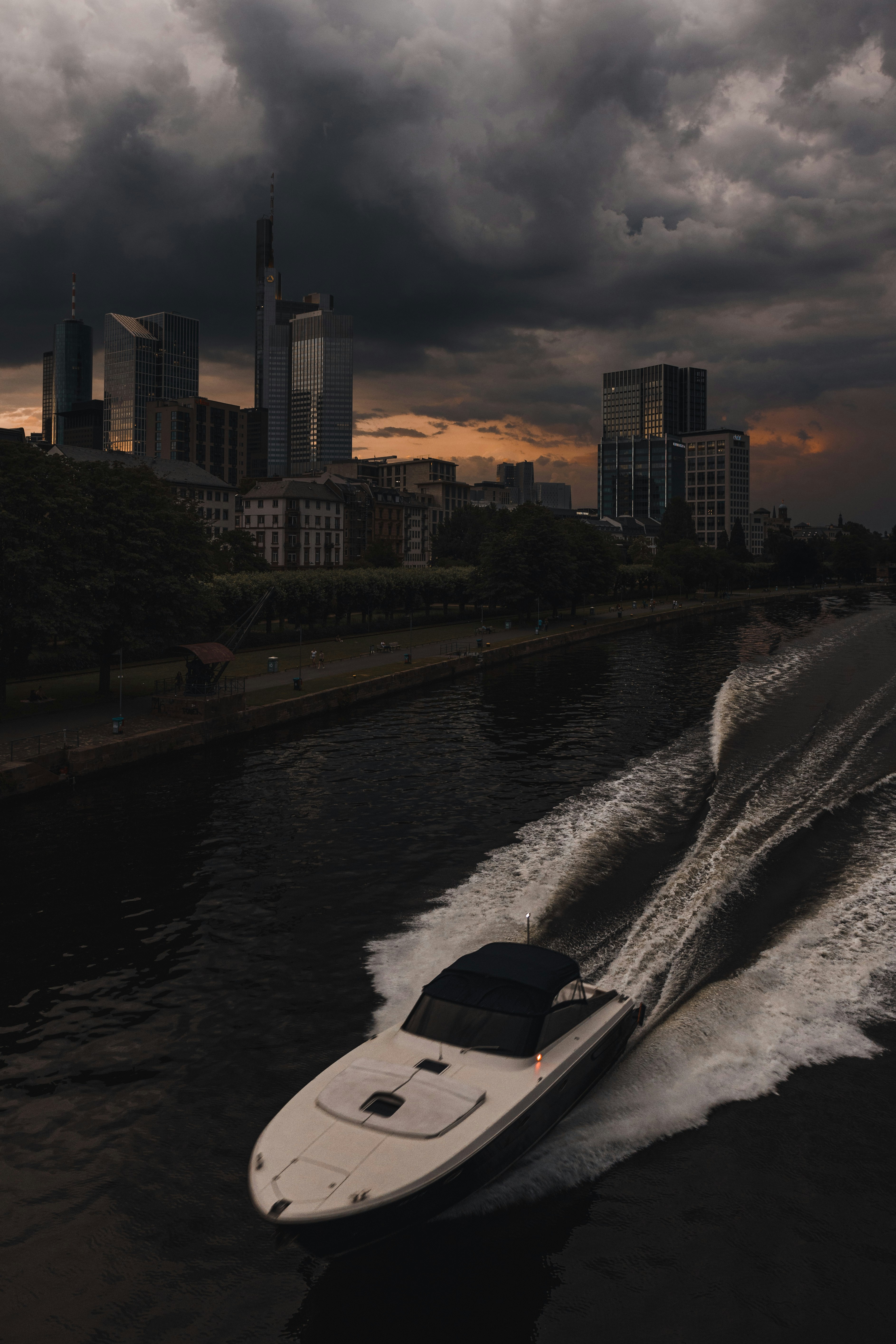 Moonlit Wake: A White Yacht Slices Through a Slumbering River City