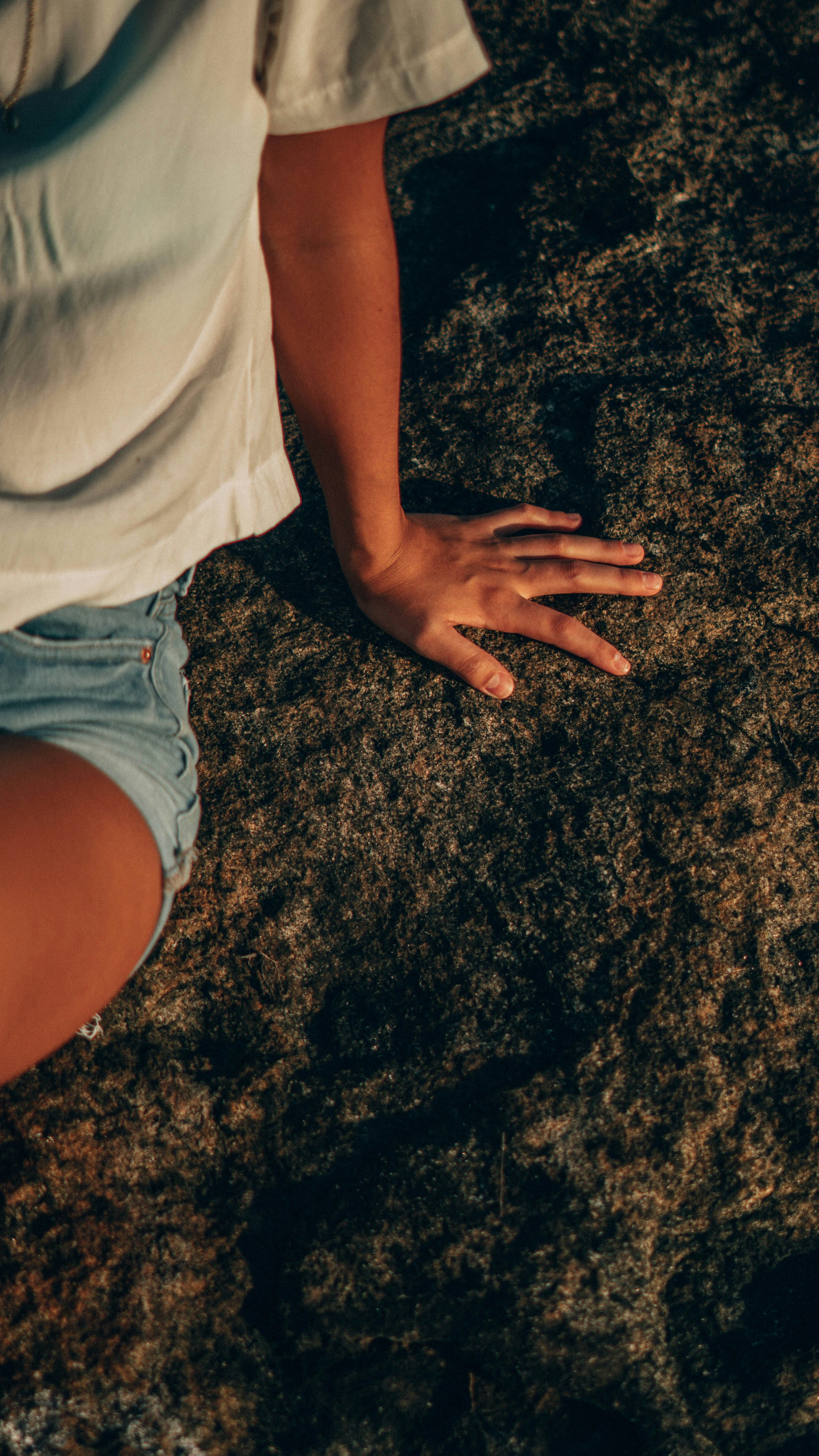 A person sitting on the ground with their hand on the ground photo ...