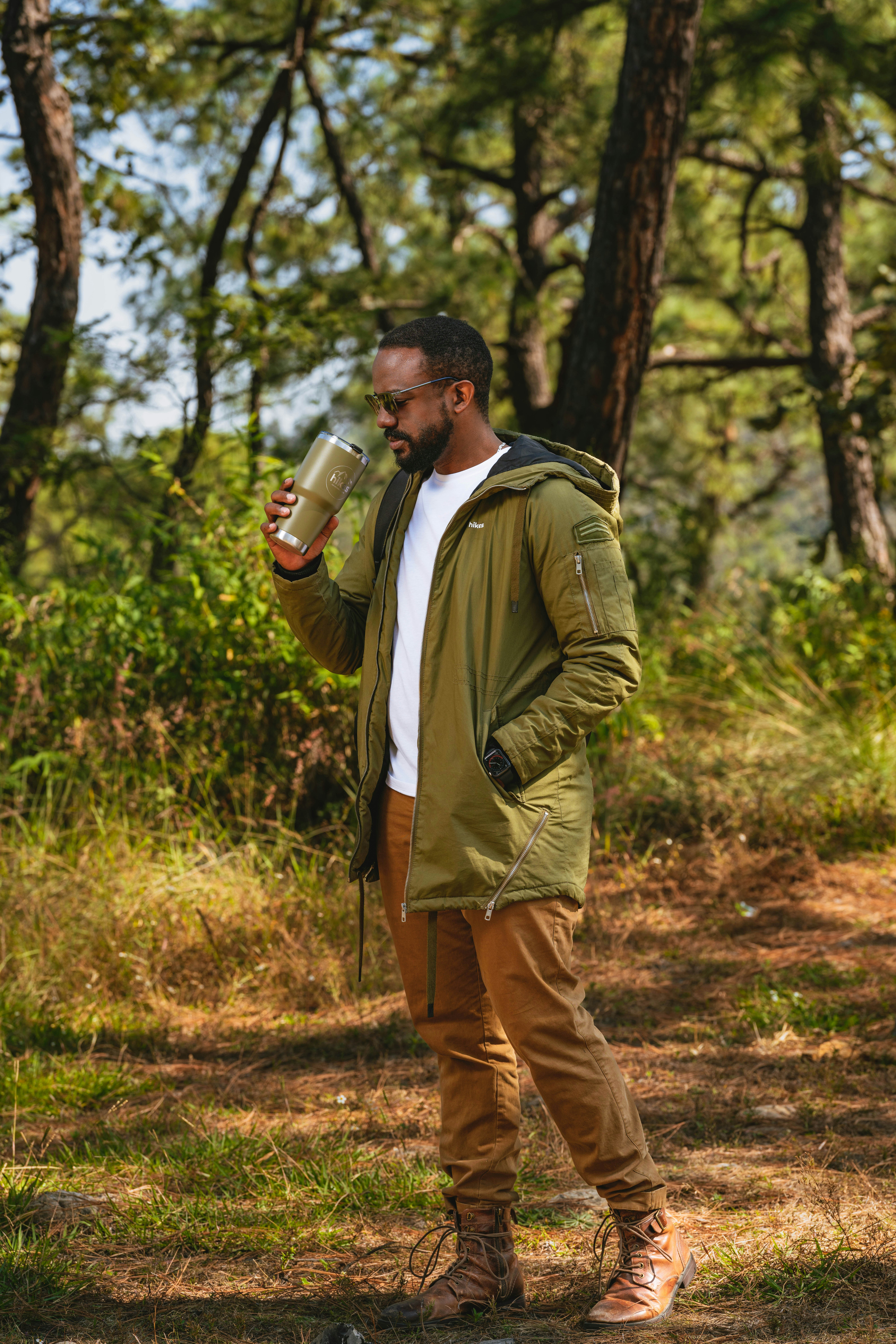 Male man walking in the woods while drinking his coffee