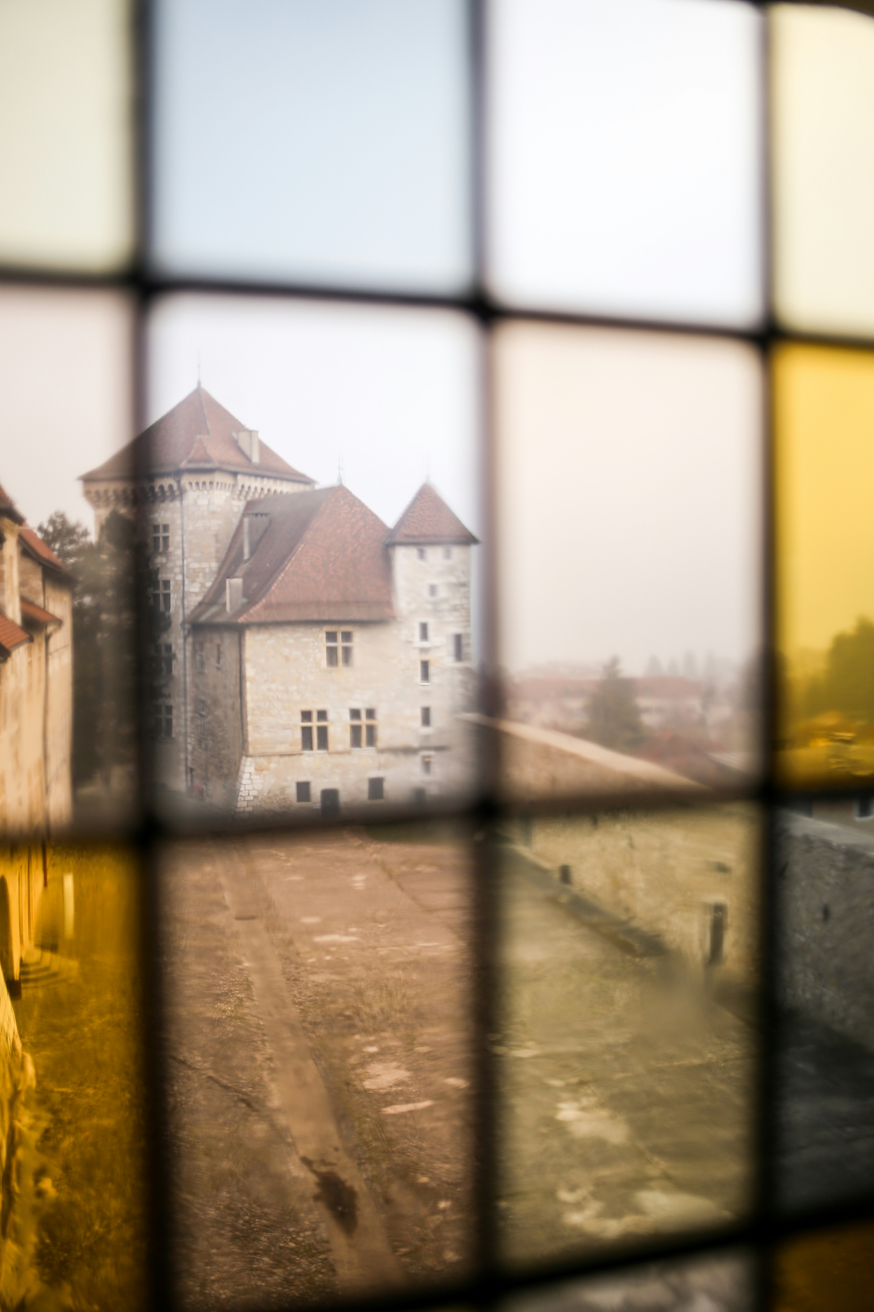 Castle Through the Glass Grid: A Fortress Framed by Colored Panes