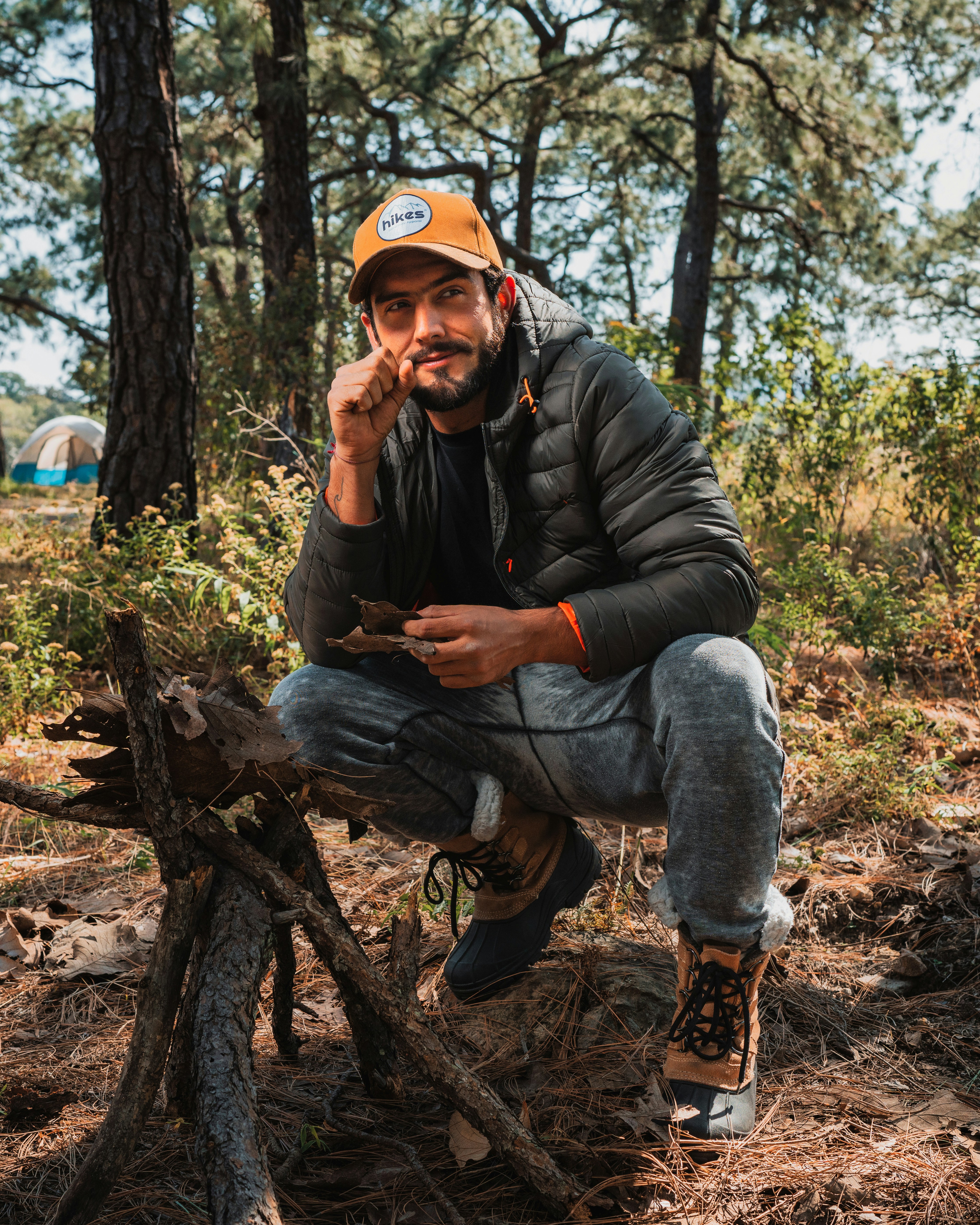 Male hiker preparing his fire pit in a cold winter morning