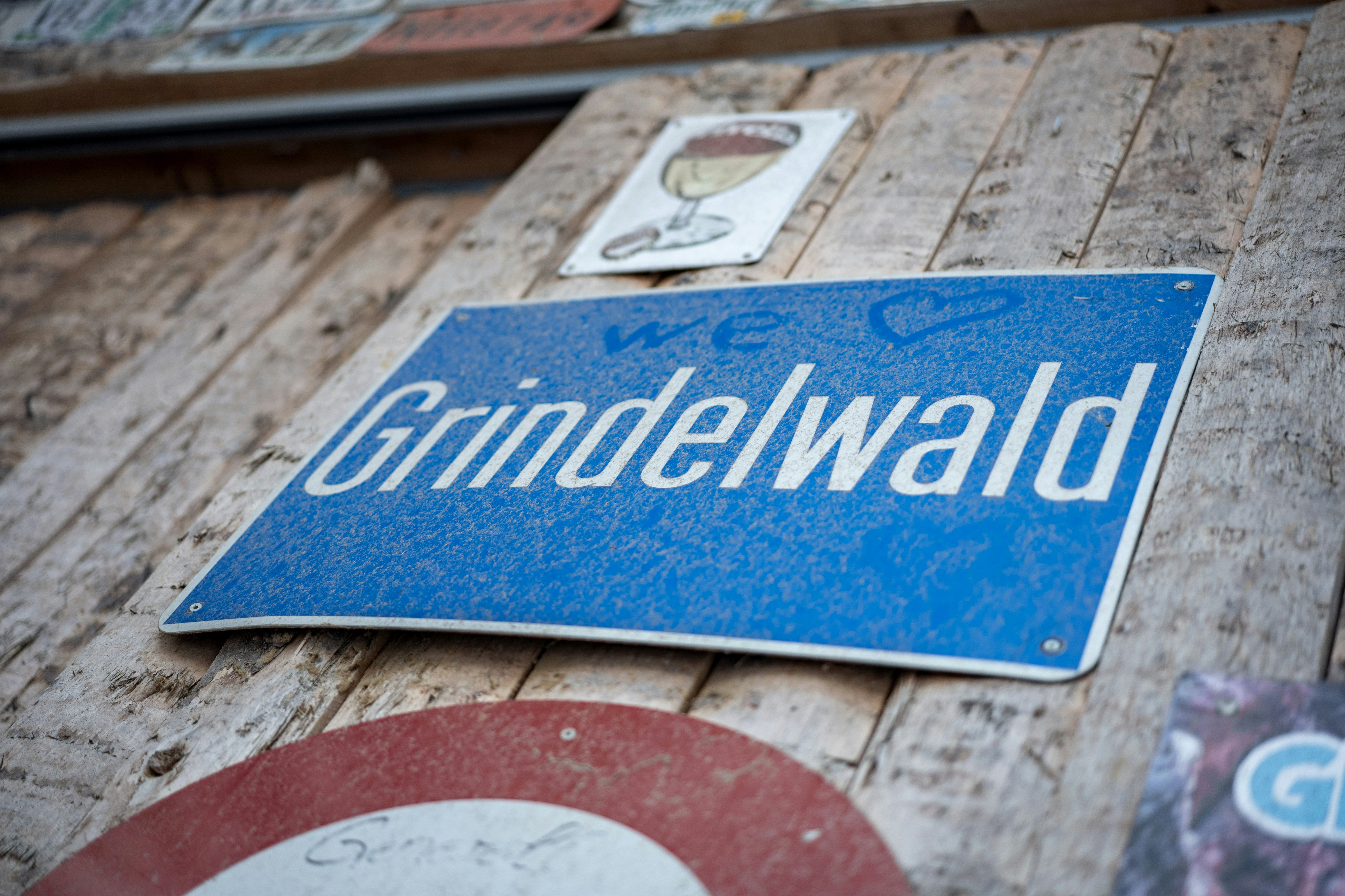 A blue sign that is on the side of a building photo – Free Grindelwald ...