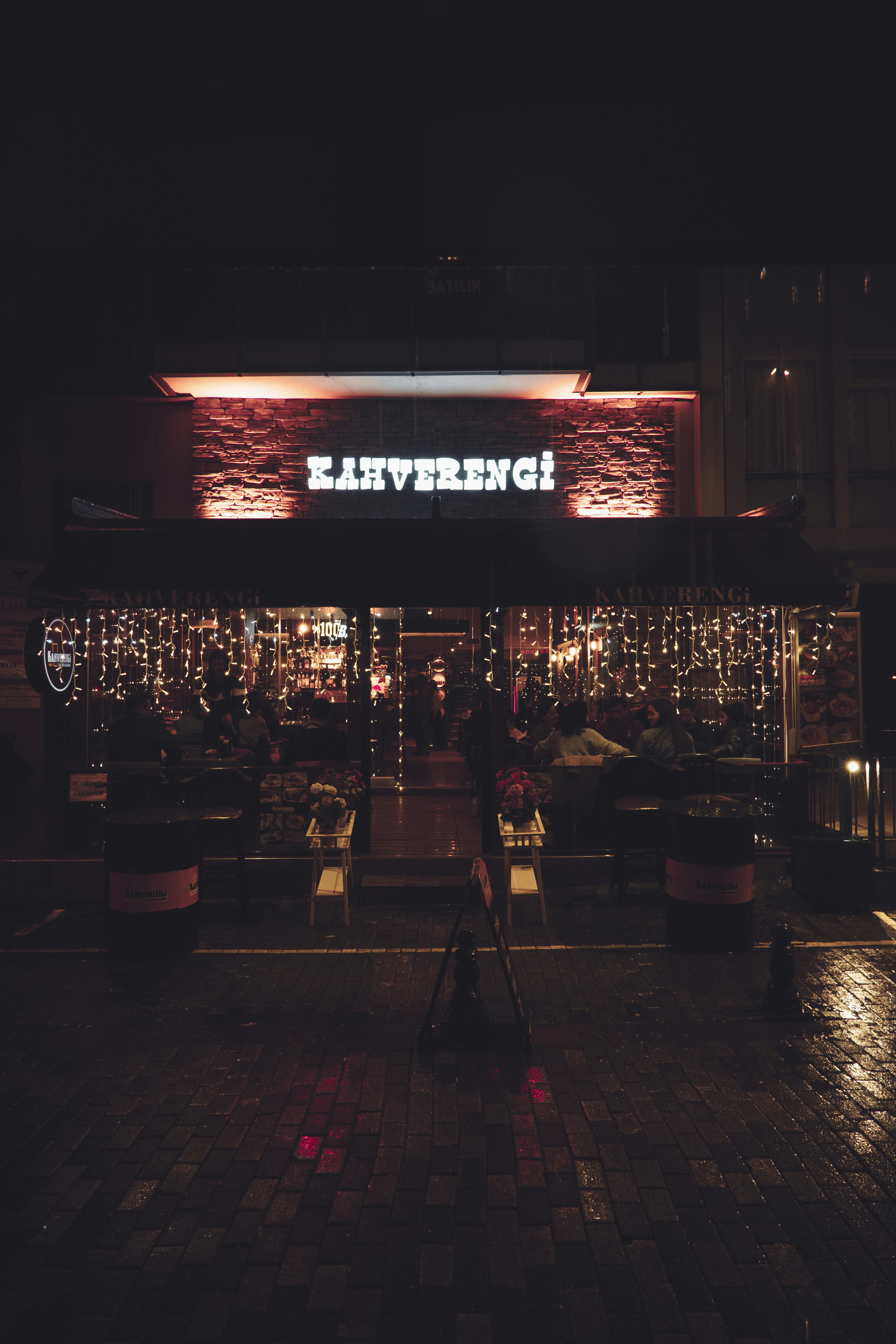 A building with a lit up sign on the front of it photo – Free Shop ...