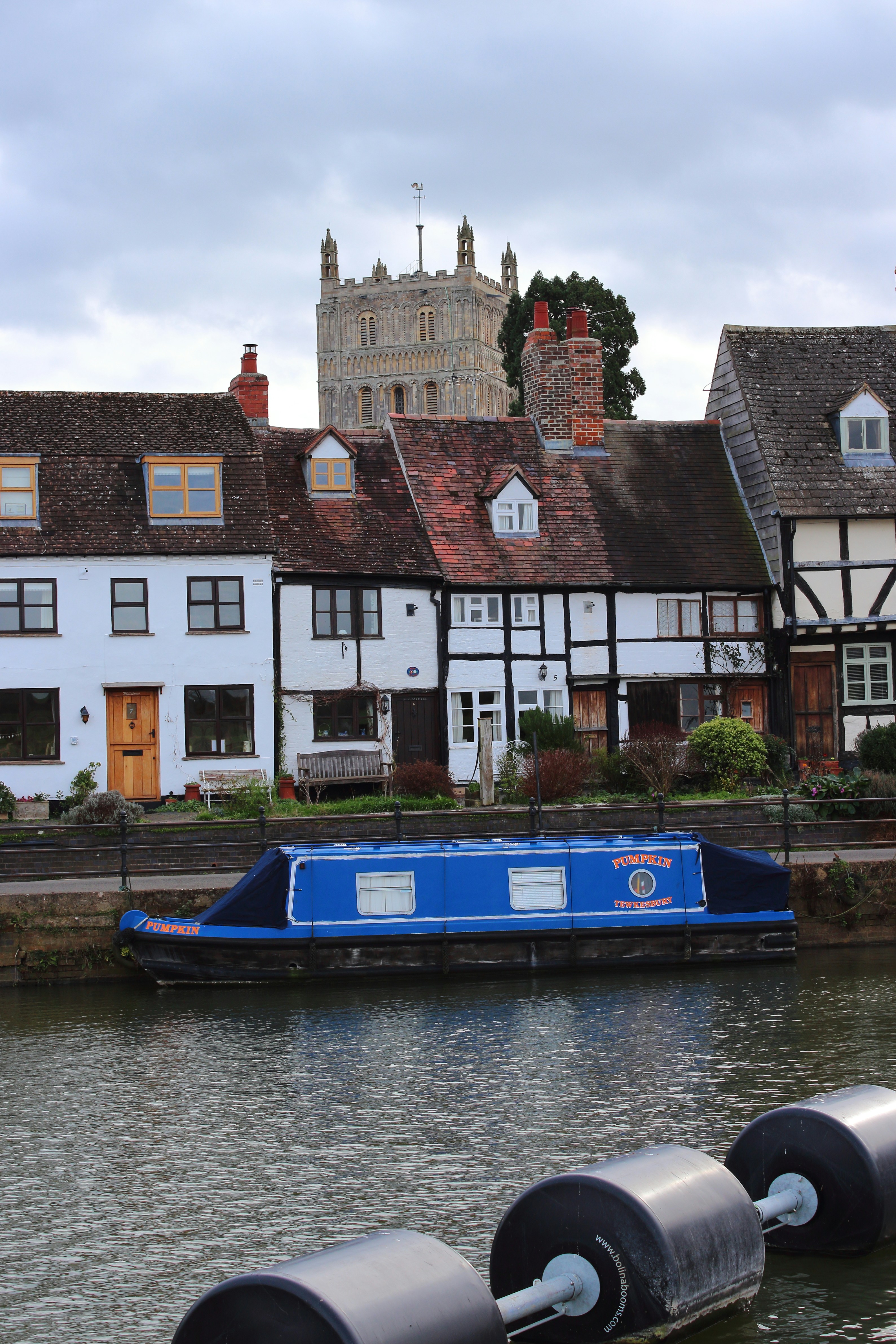 A blue boat floating down a river next to tall buildings photo – Free ...