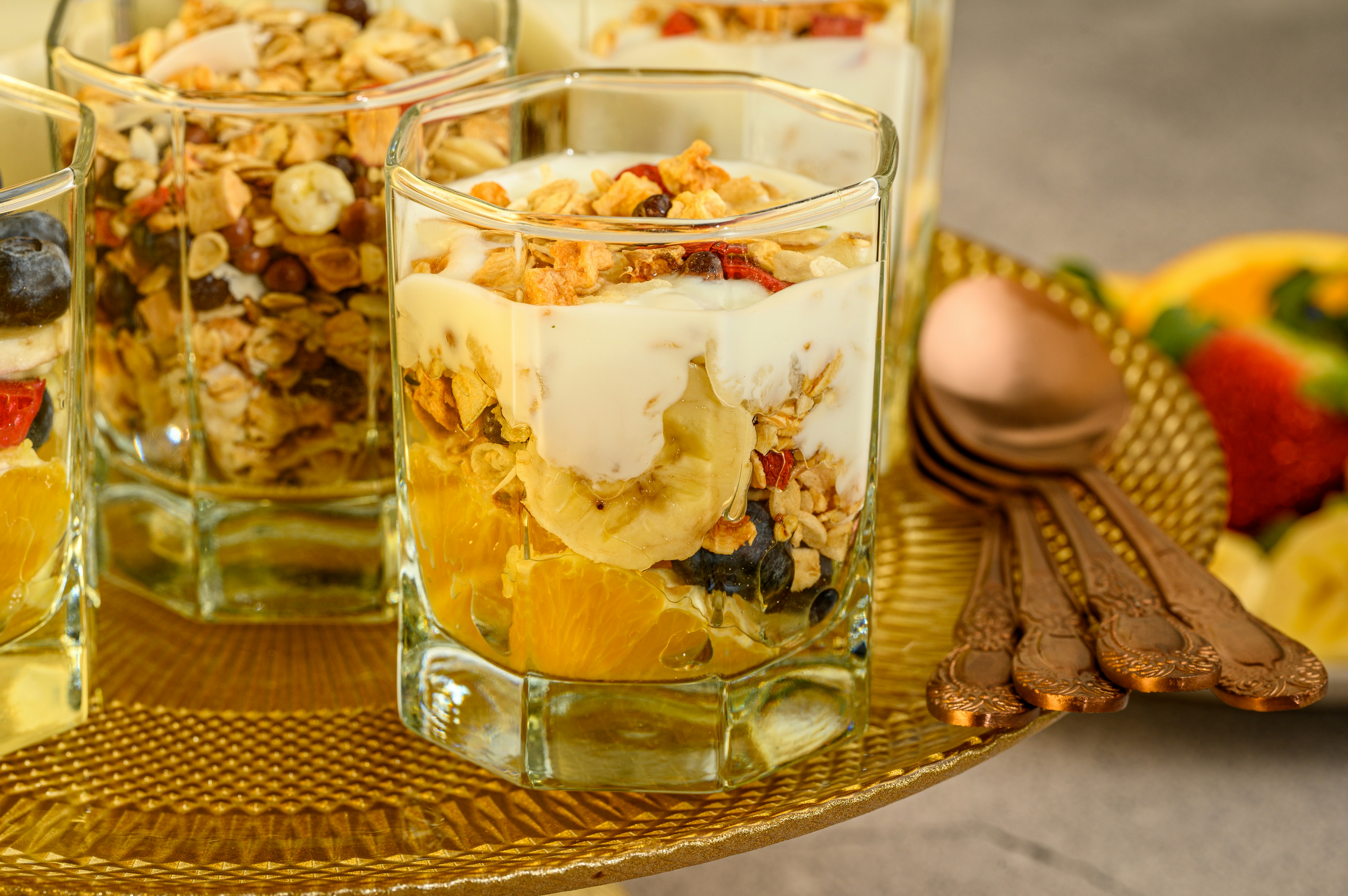 Creamy Banana-Yogurt Parfaits Crowned by Citrus on a Golden Tray
