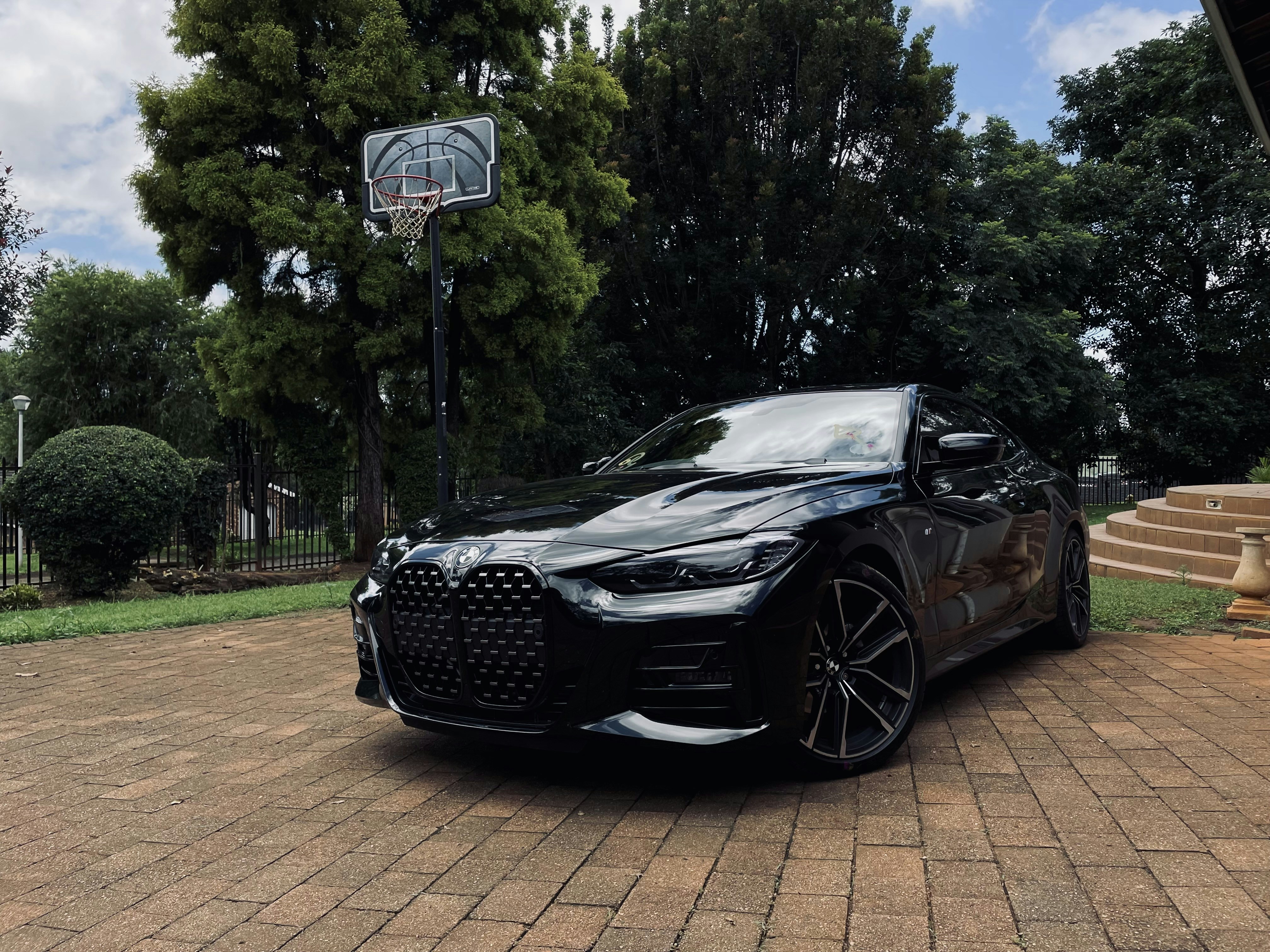 A black sports car parked in front of a basketball hoop photo – Free ...