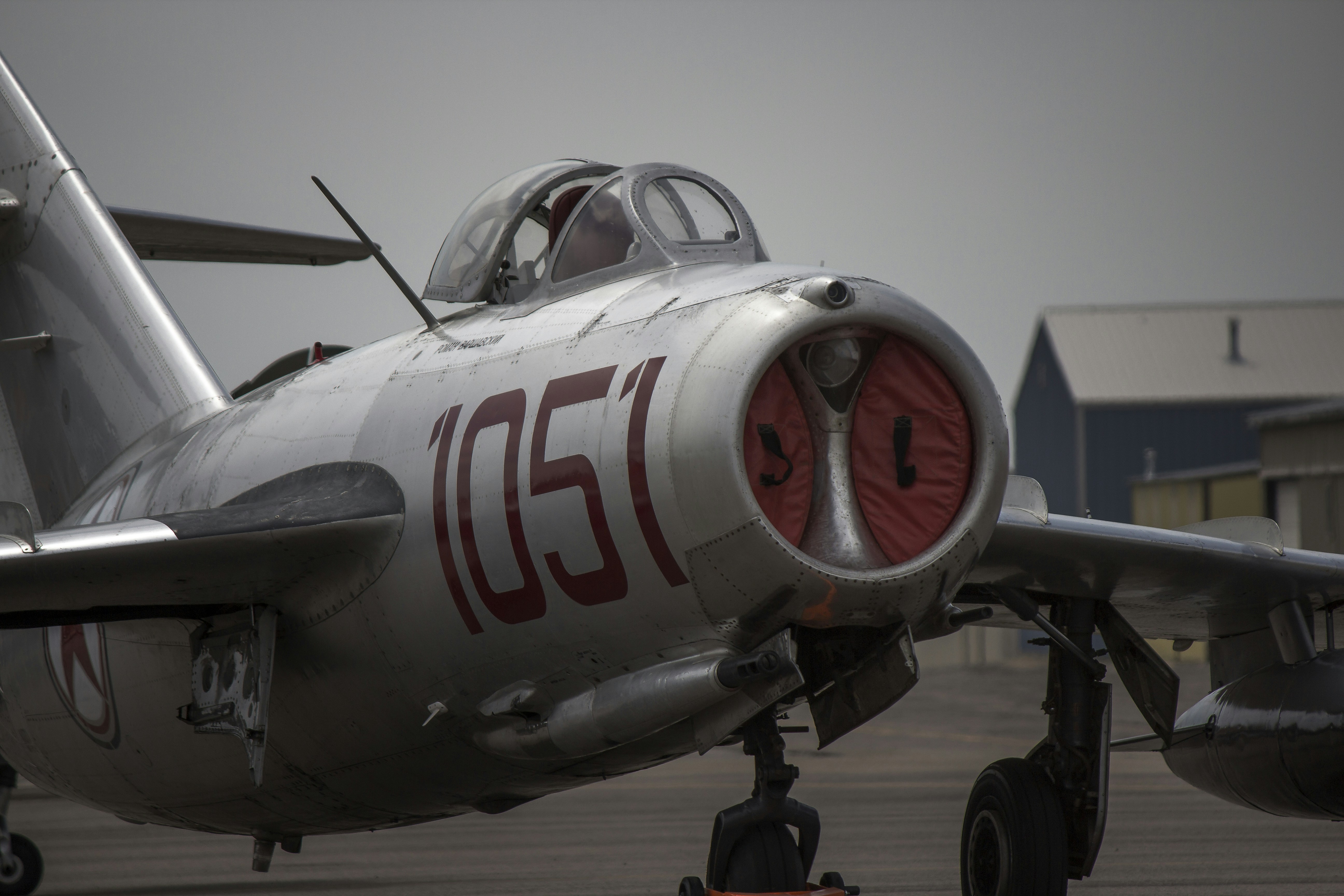 A silver fighter jet sitting on top of an airport tarmac photo – Free ...