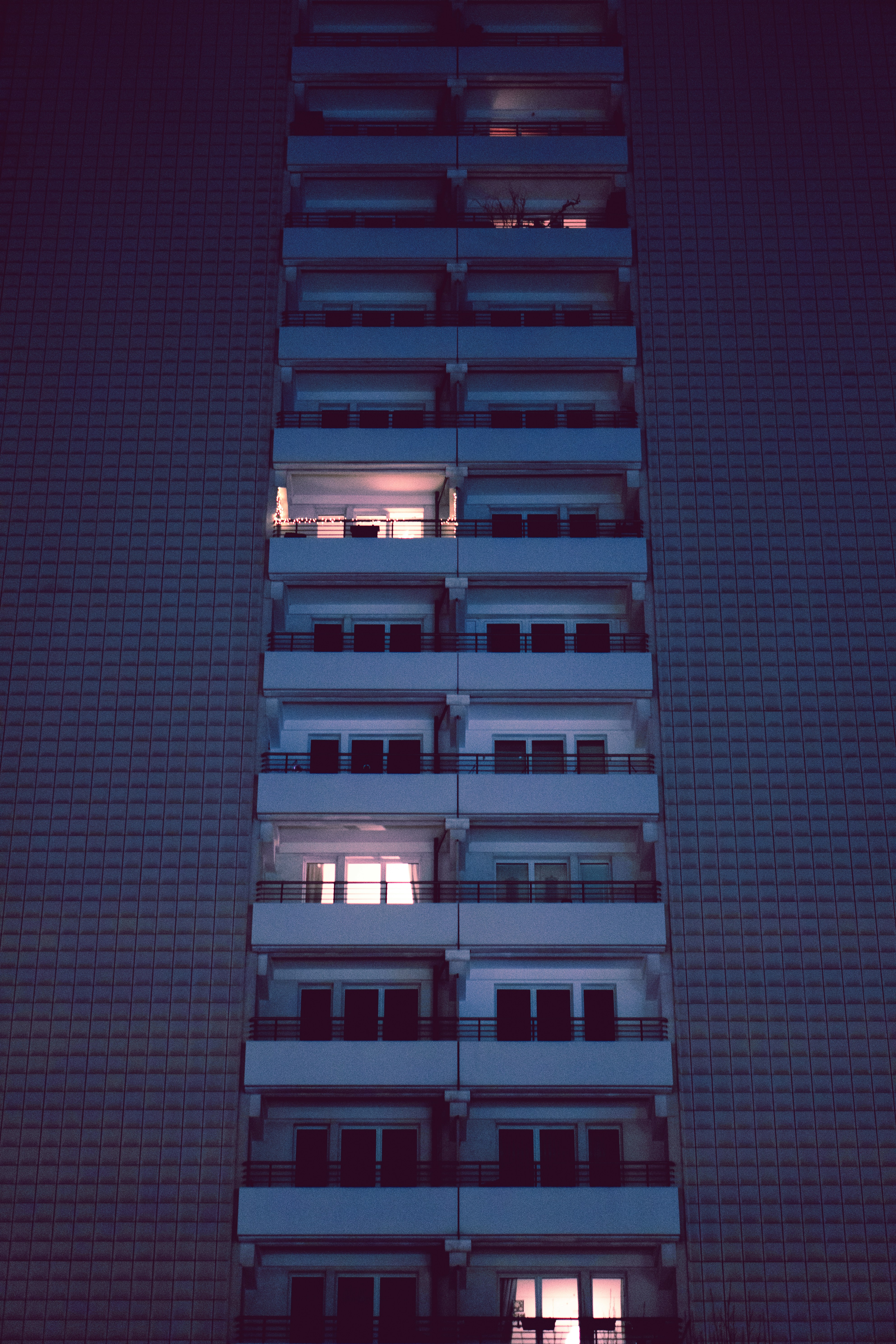 A very tall building with windows lit up at night photo – Free ...