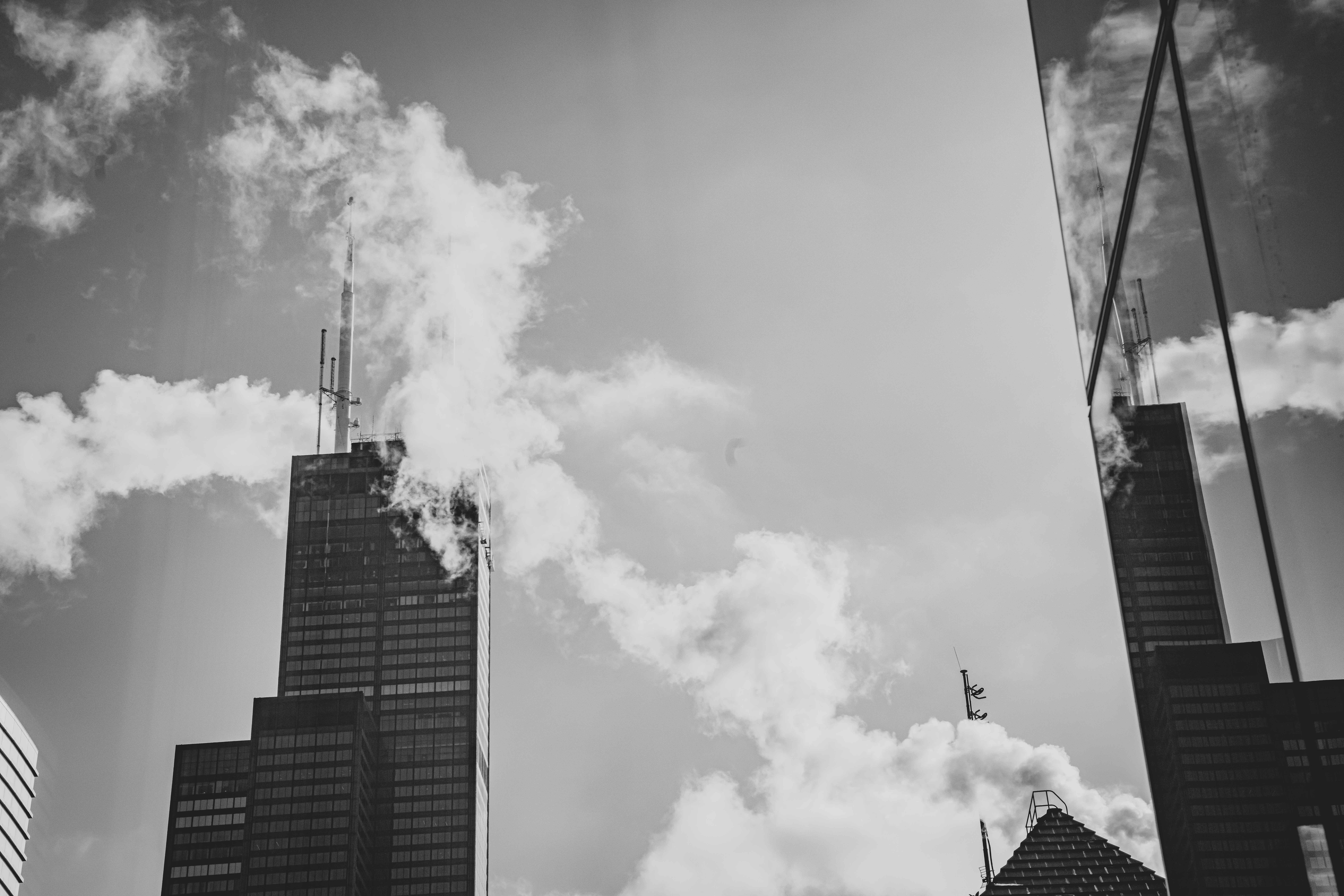 Smoke Trails Over Skyscrapers: A Quiet Monochrome Noon