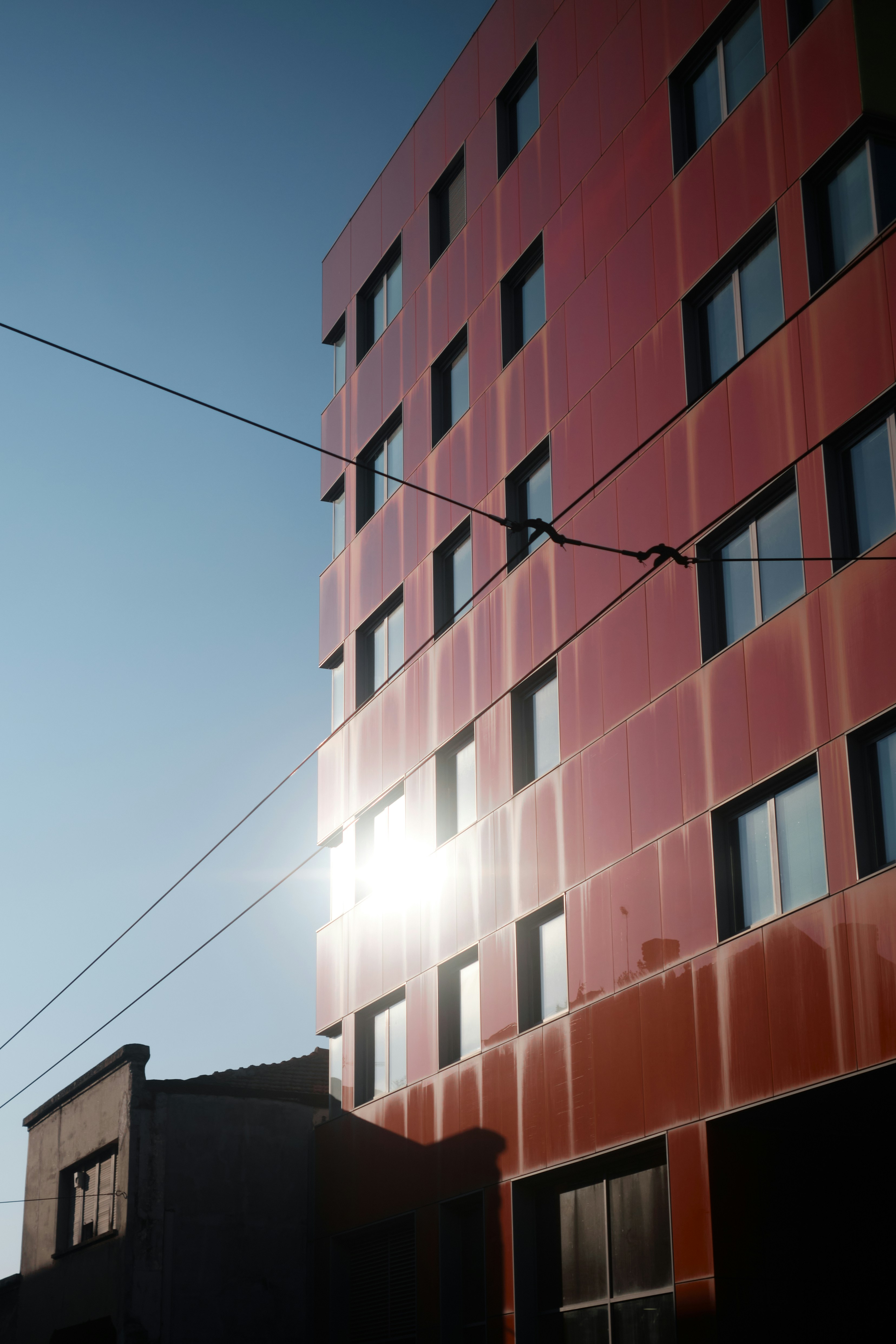 A tall red building sitting next to a power line photo – Free Milano ...